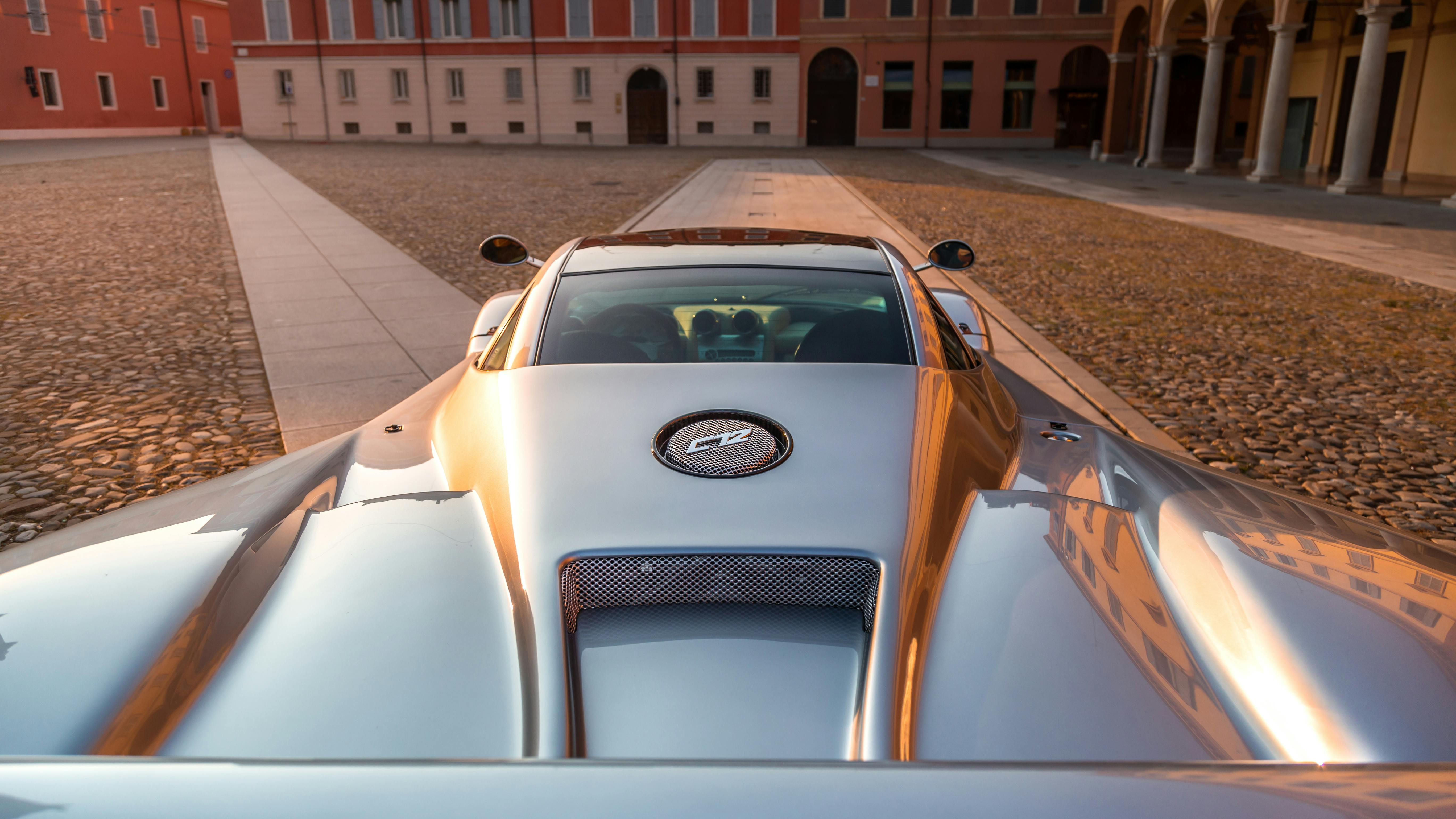 Sleek Silver Hypercar in Sunlit Courtyard · Free Stock Photo