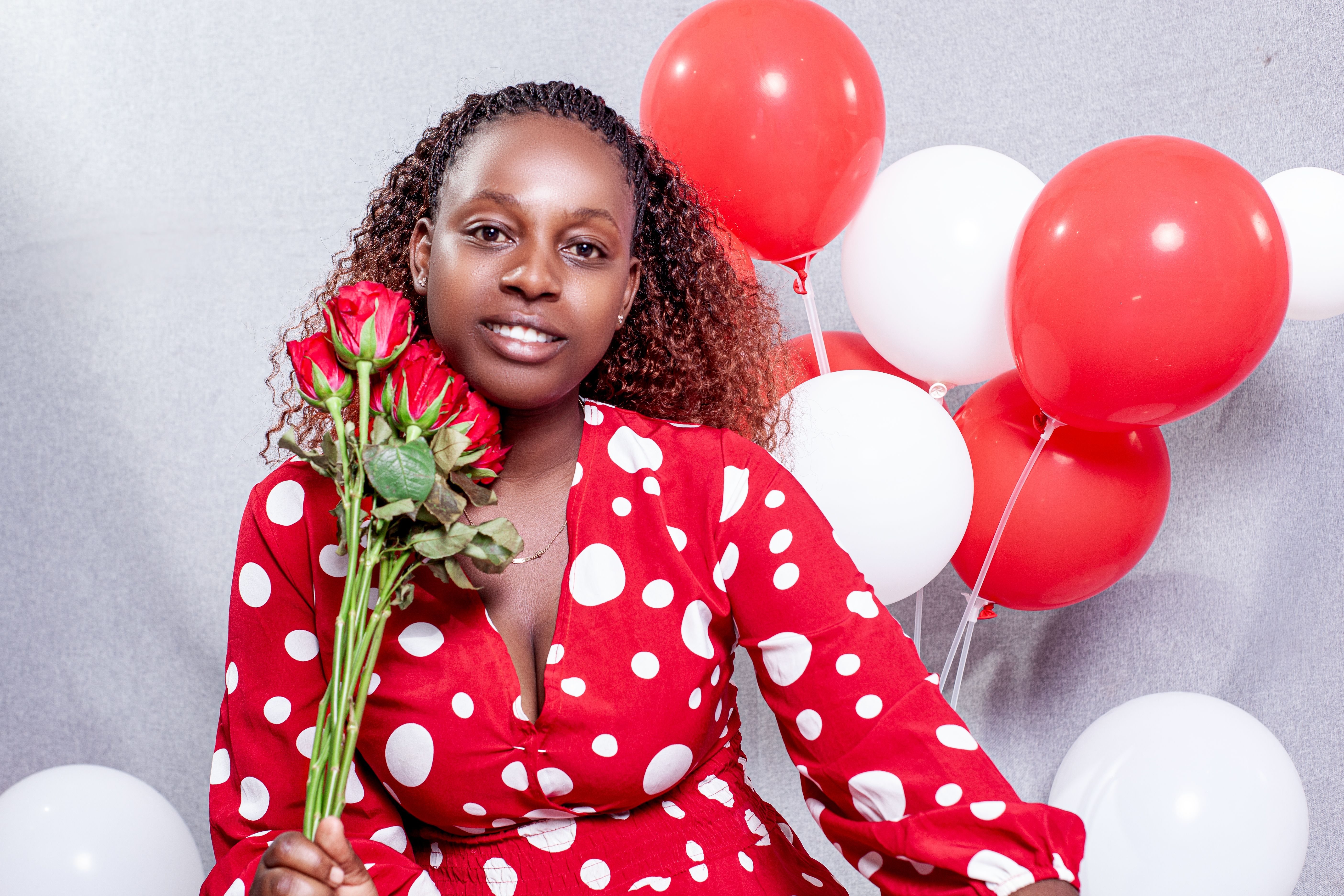 Smiling Woman in Red Polka Dot Dress with Roses · Free Stock Photo