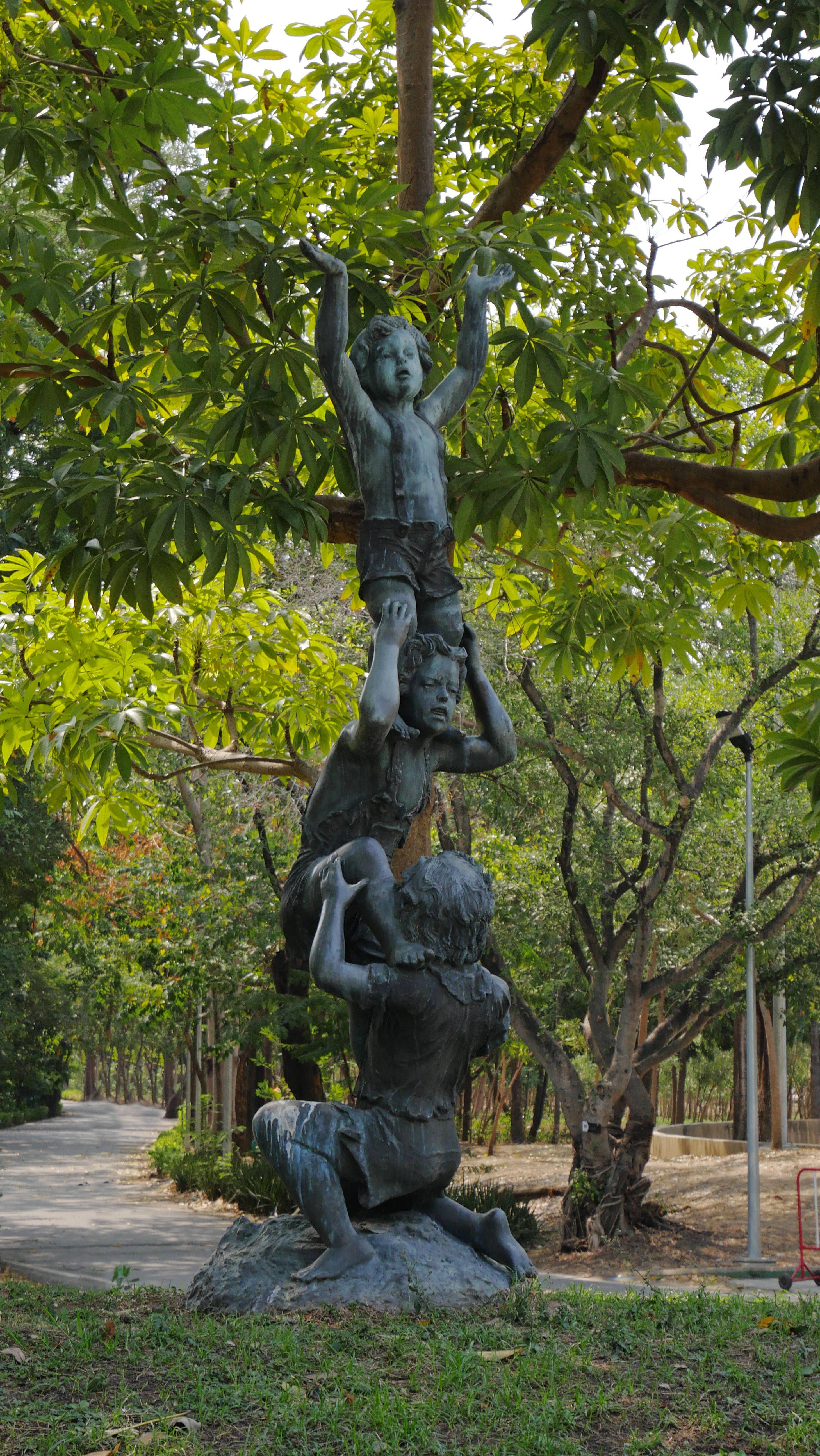 Bronze Statue of Children in Lush Park Setting · Free Stock Photo