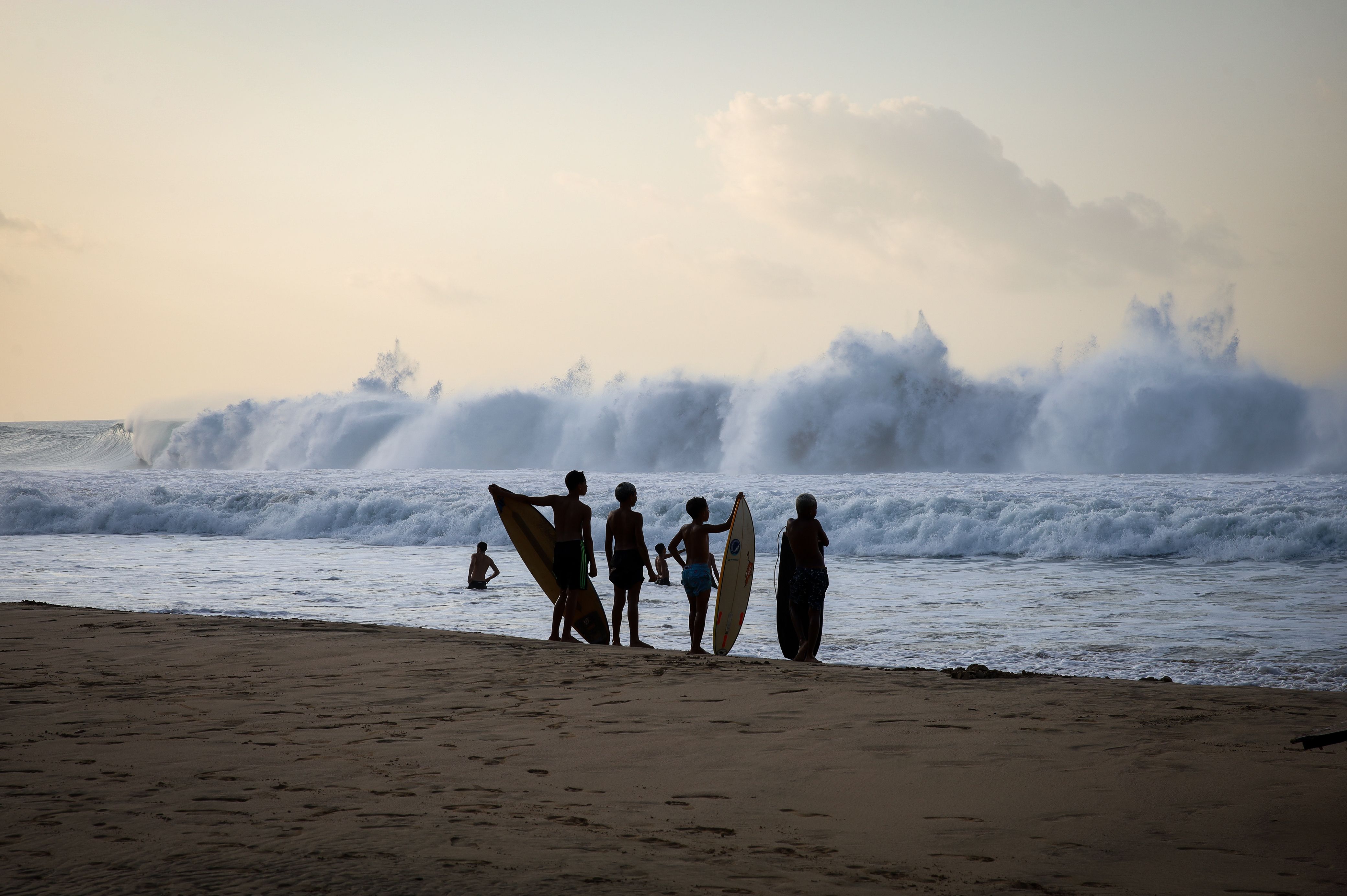 Surfers on Beach with Huge Waves at Sunset · Free Stock Photo
