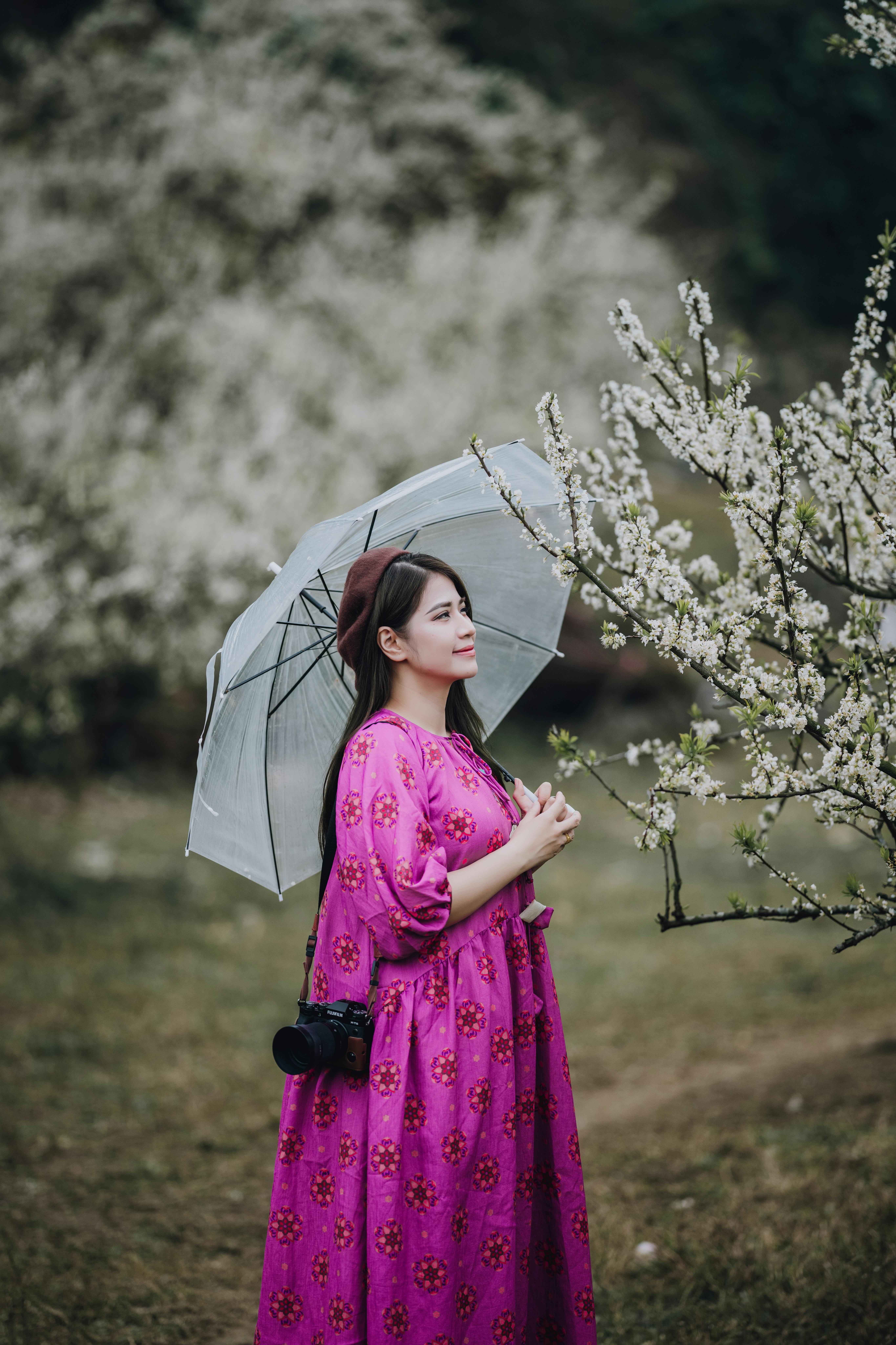 Femme Avec Parapluie Dans Un Verger En Fleurs Au Printemps · Photo gratuite