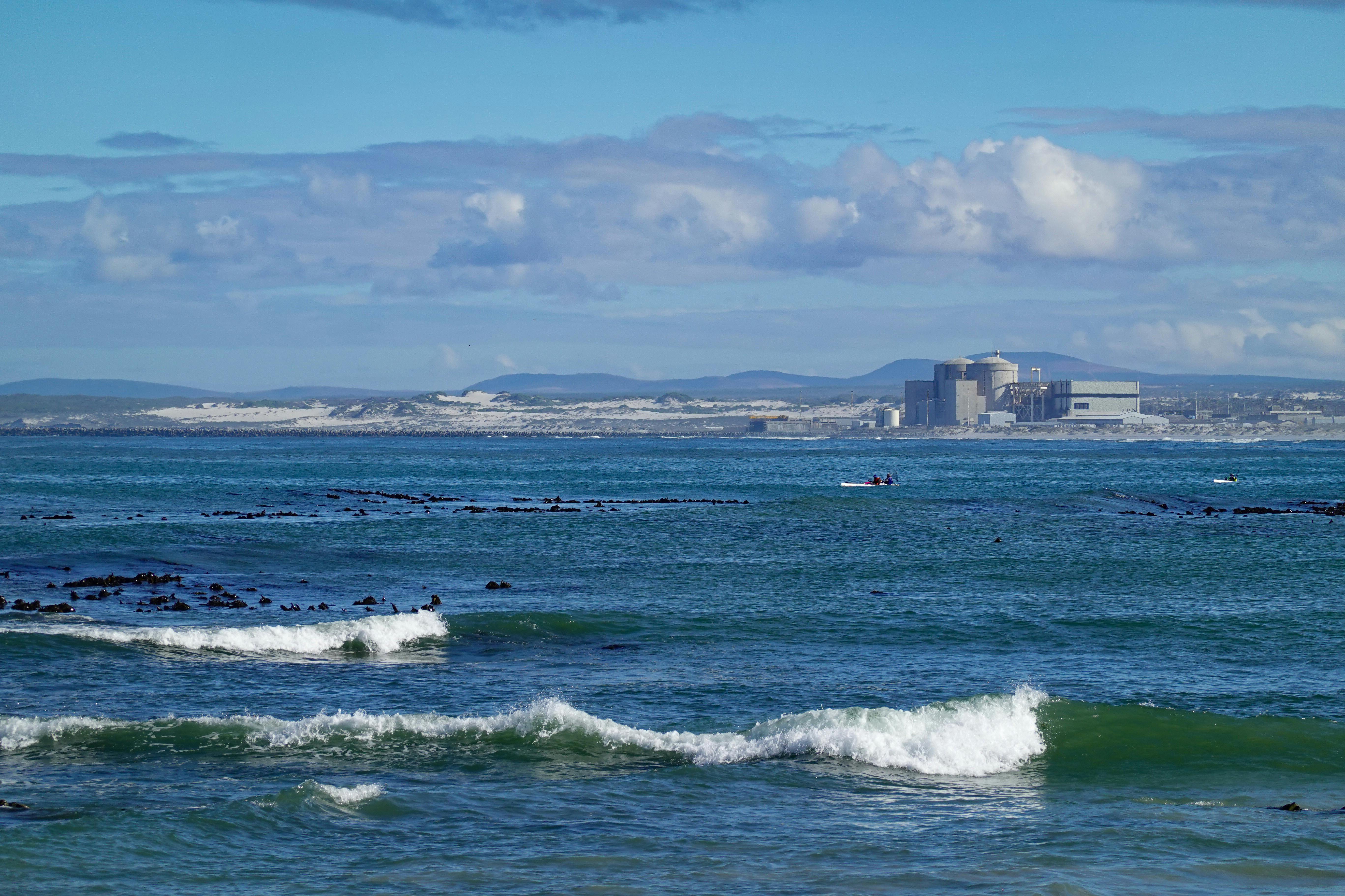 Scenic Wave-Crested Ocean with Distant Industry · Free Stock Photo