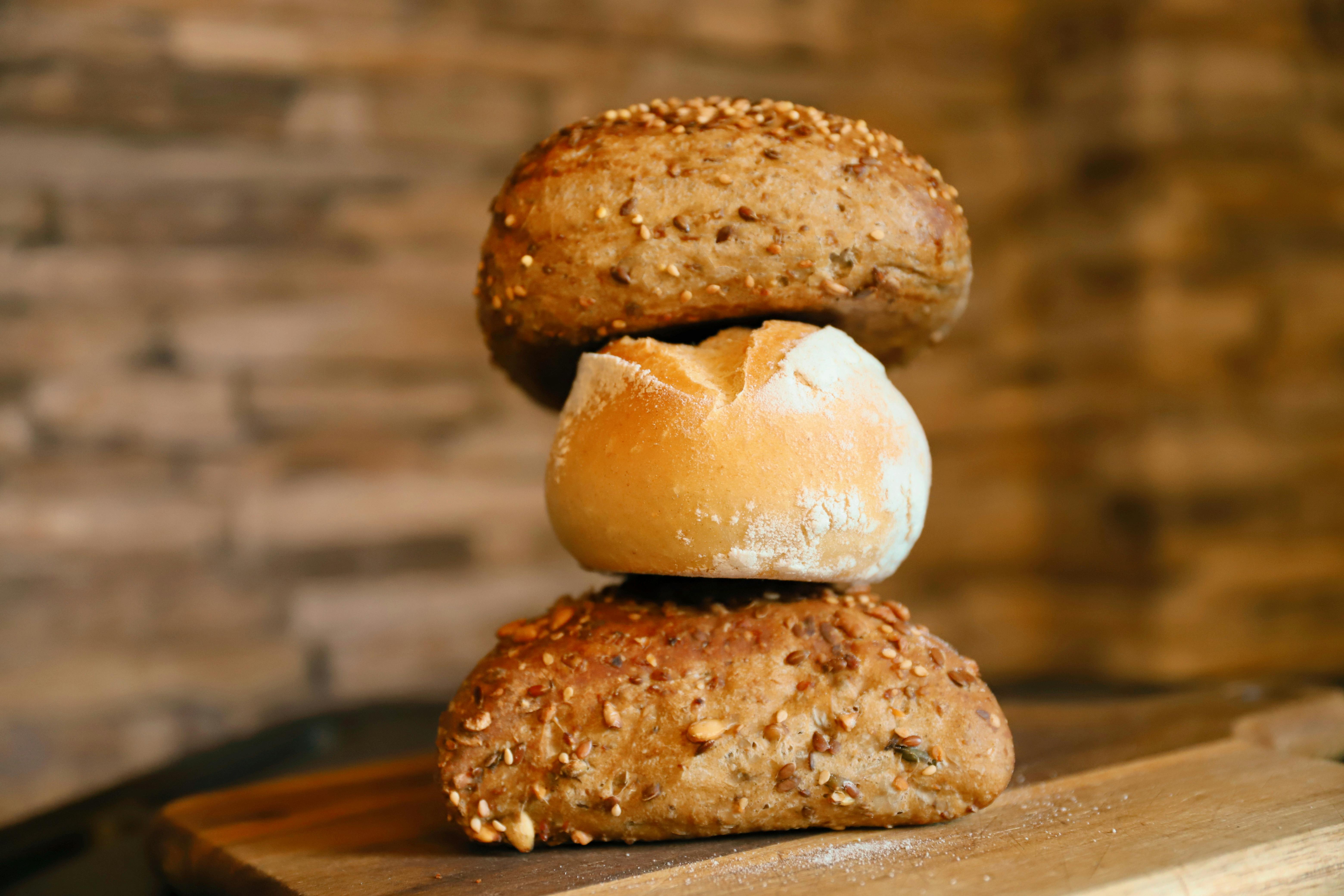 Rustic Artisan Bread Trio on Wooden Surface · Free Stock Photo