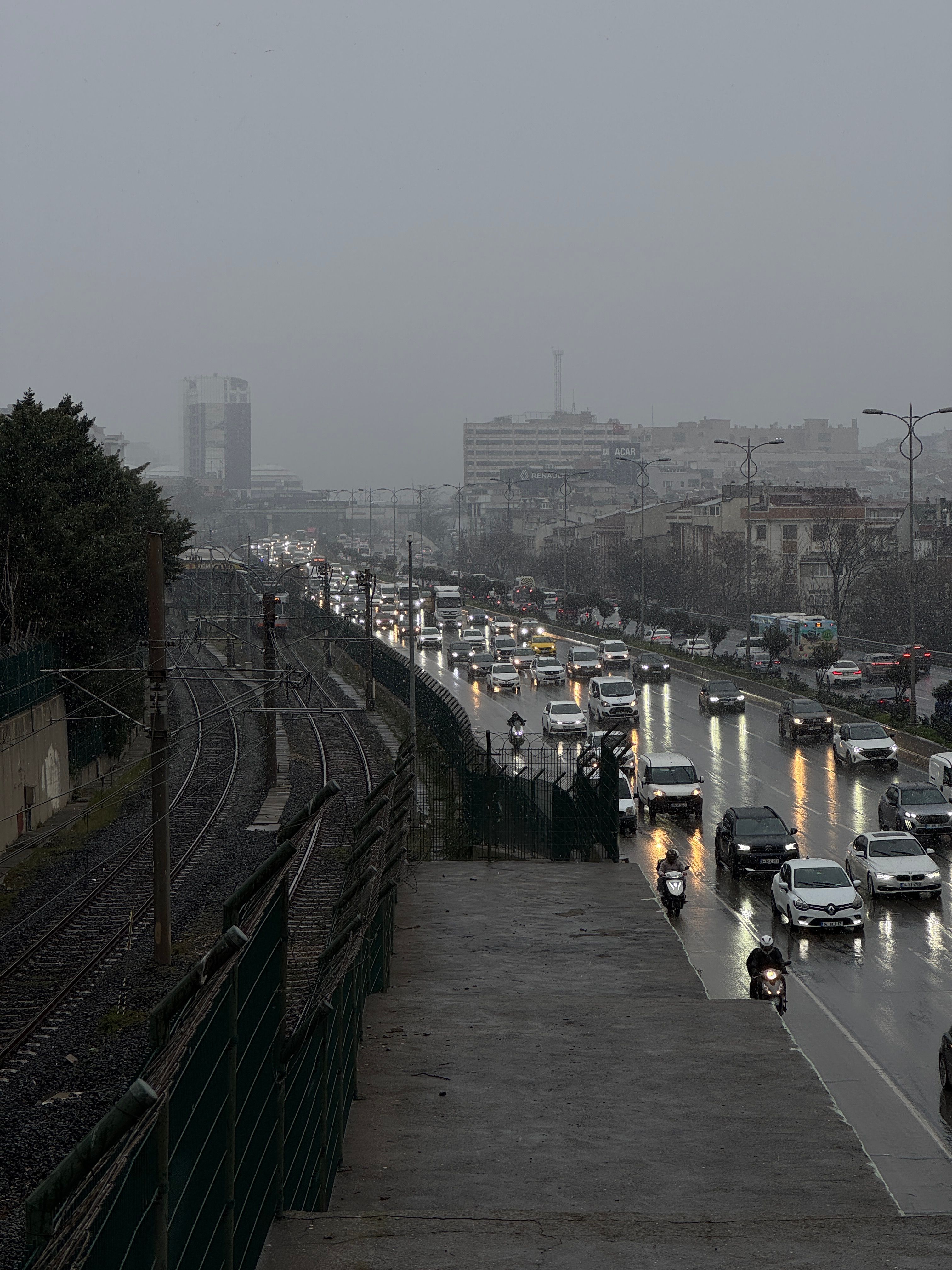 Rainy Urban Evening Traffic Scene with Trains · Free Stock Photo