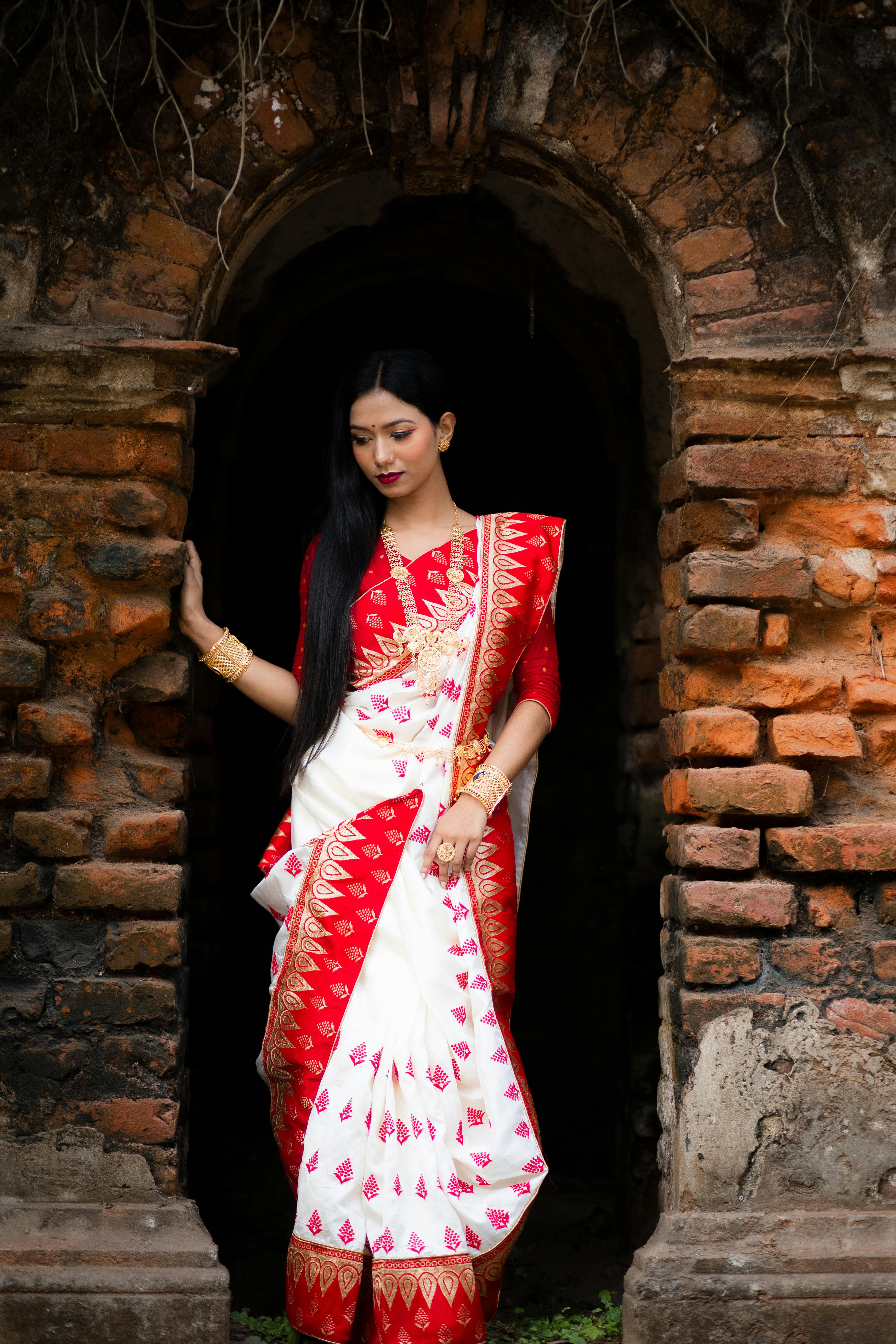 Woman in Traditional Red and White Sari by Rustic Archway · Free Stock ...