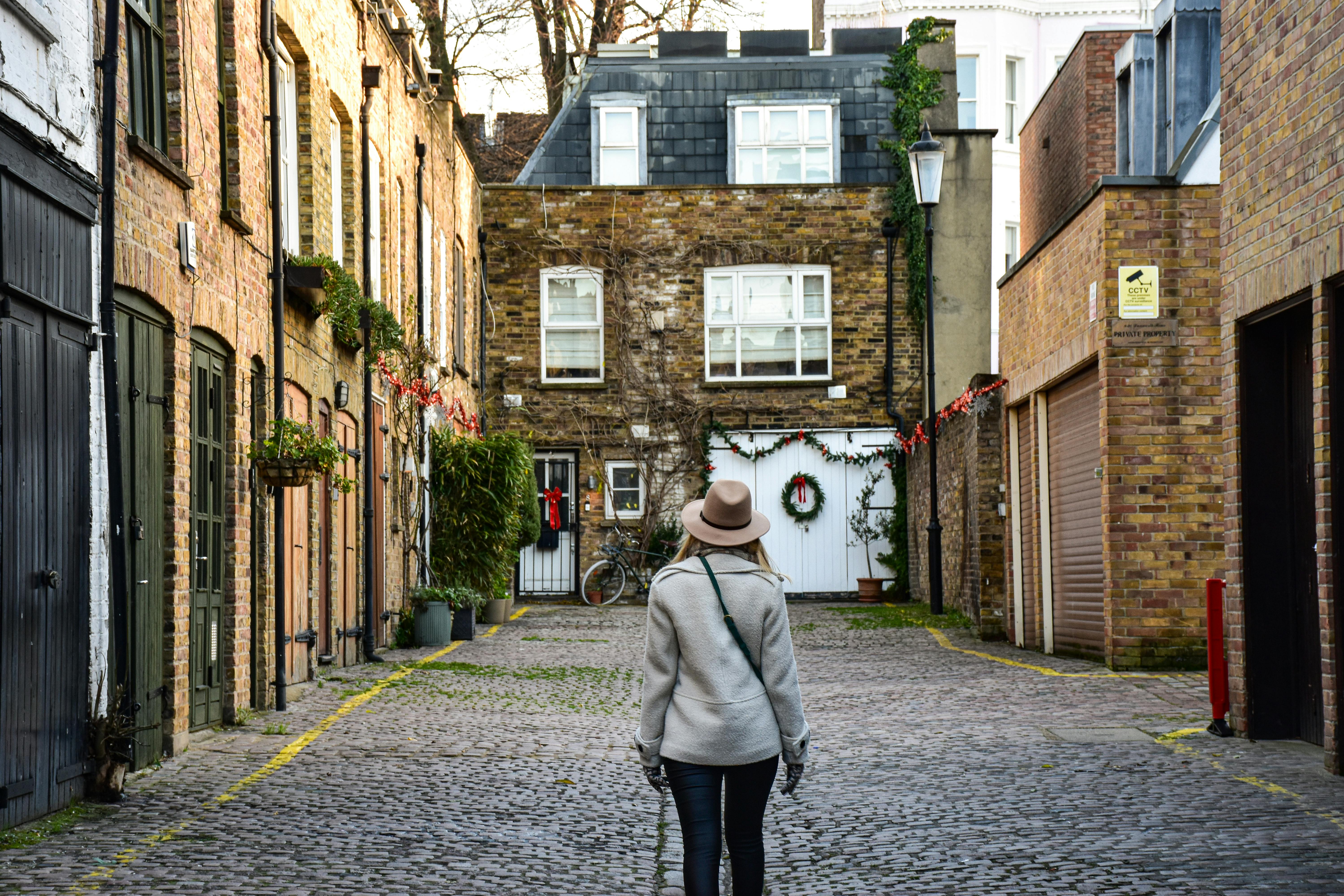 Woman Strolling Through a Quaint London Alleyway · Free Stock Photo