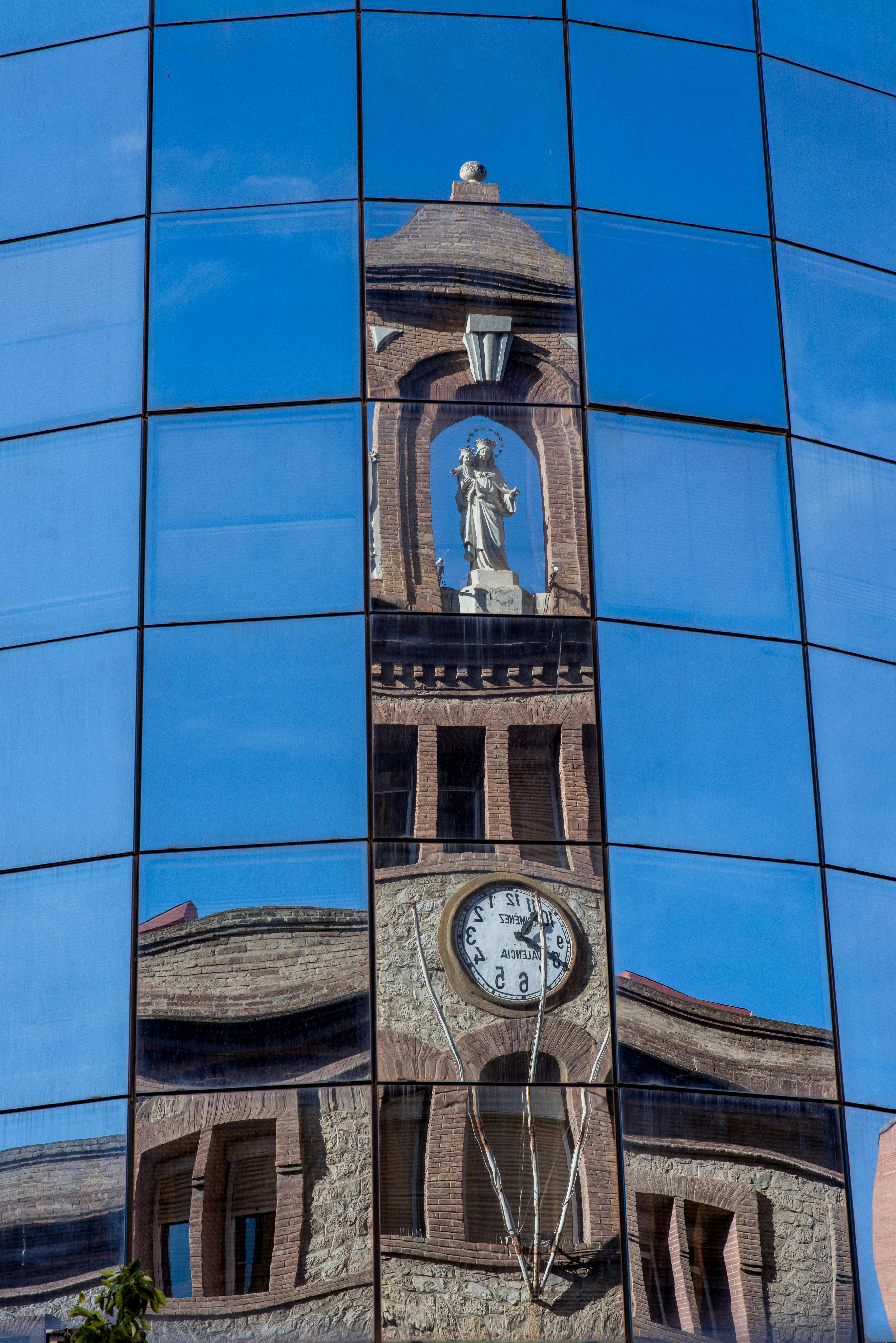 Reflective Architecture with Clock and Statue · Free Stock Photo