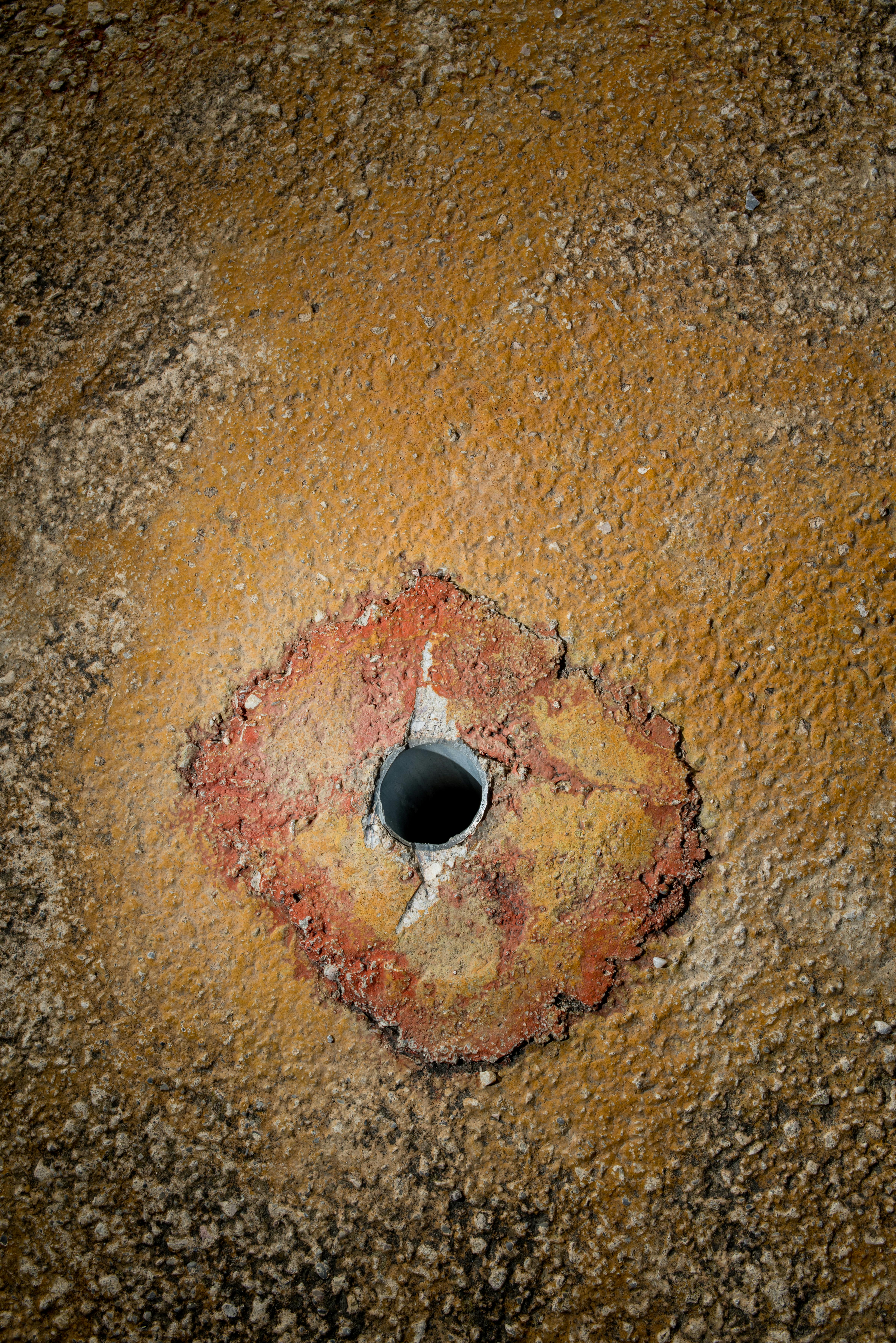 Rusted Metal Pipe in Rough Concrete Surface · Free Stock Photo