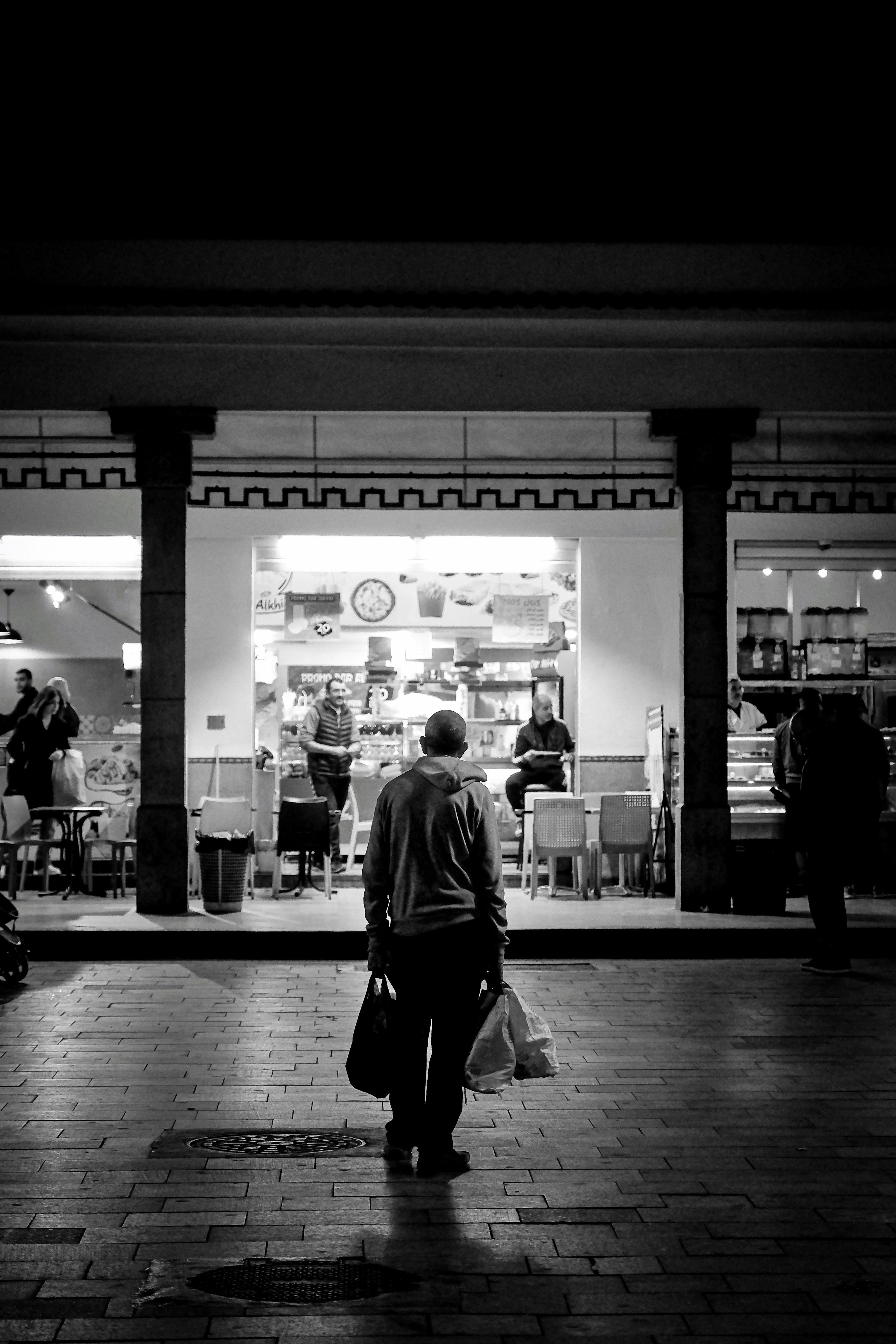 Black and White Urban Night Scene with Shopper · Free Stock Photo