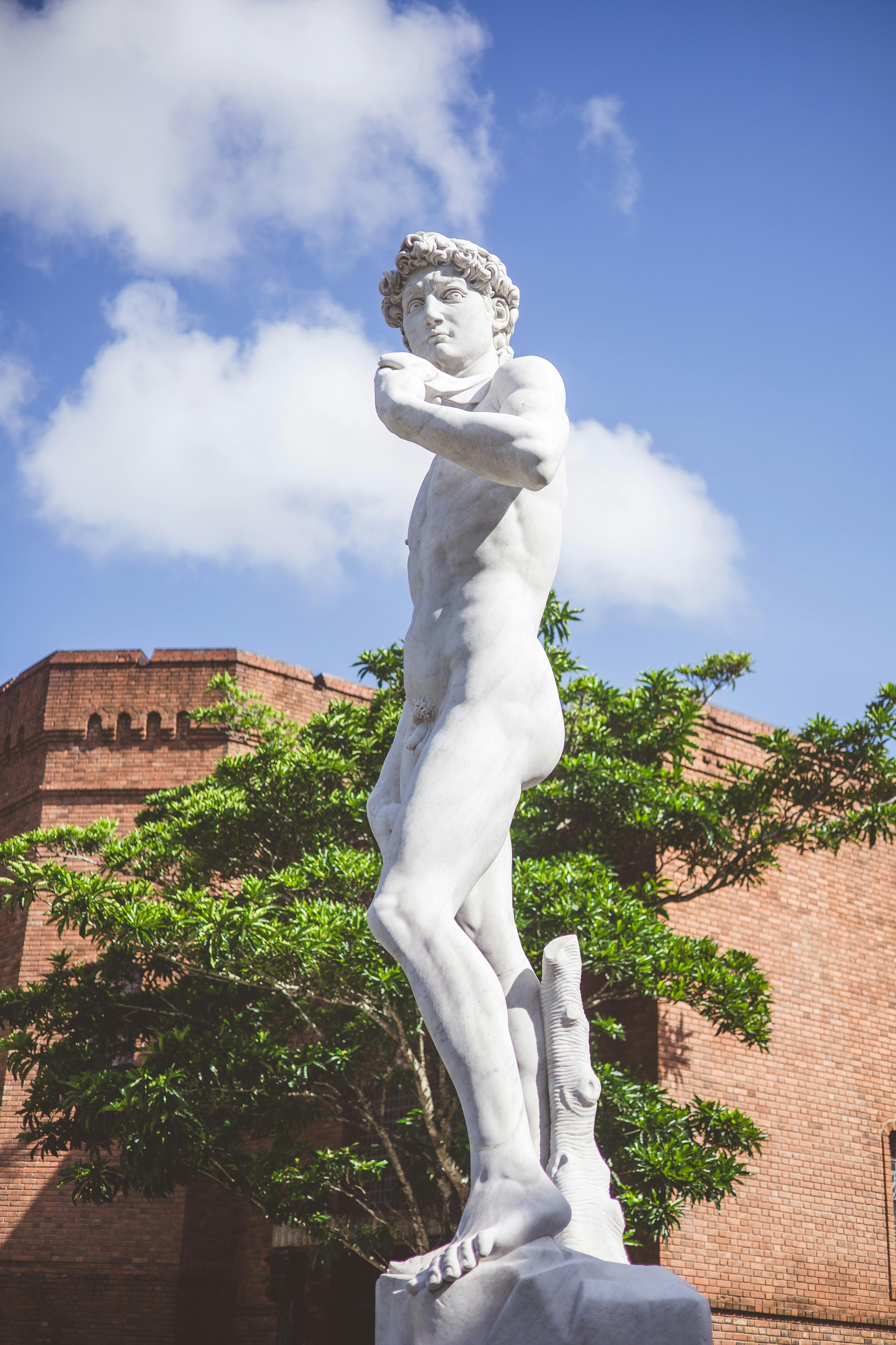 Statue of David Replica Against Historic Brick Wall · Free Stock Photo