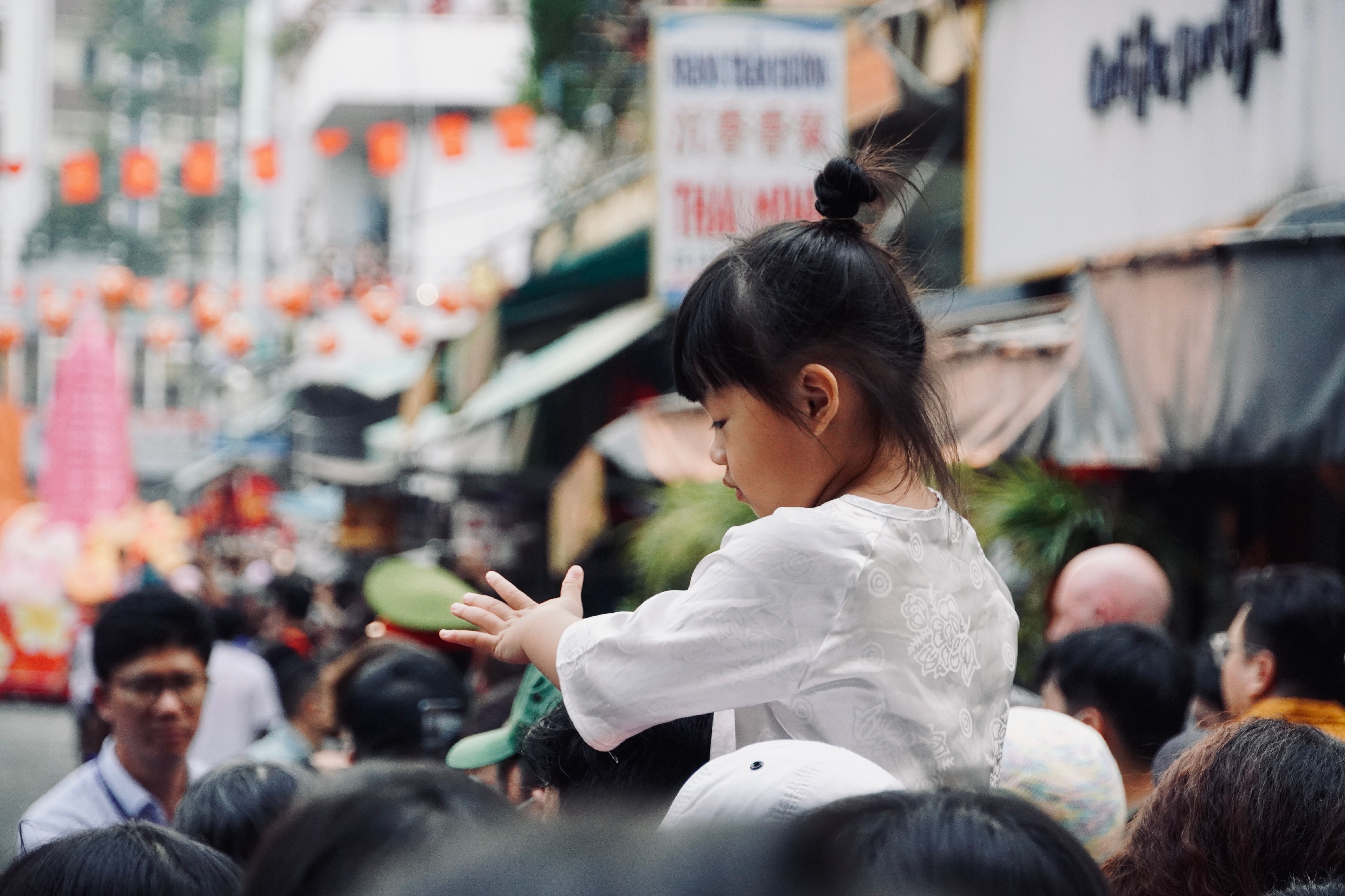 Young Girl Observing Festival Crowd Outdoors · Free Stock Photo