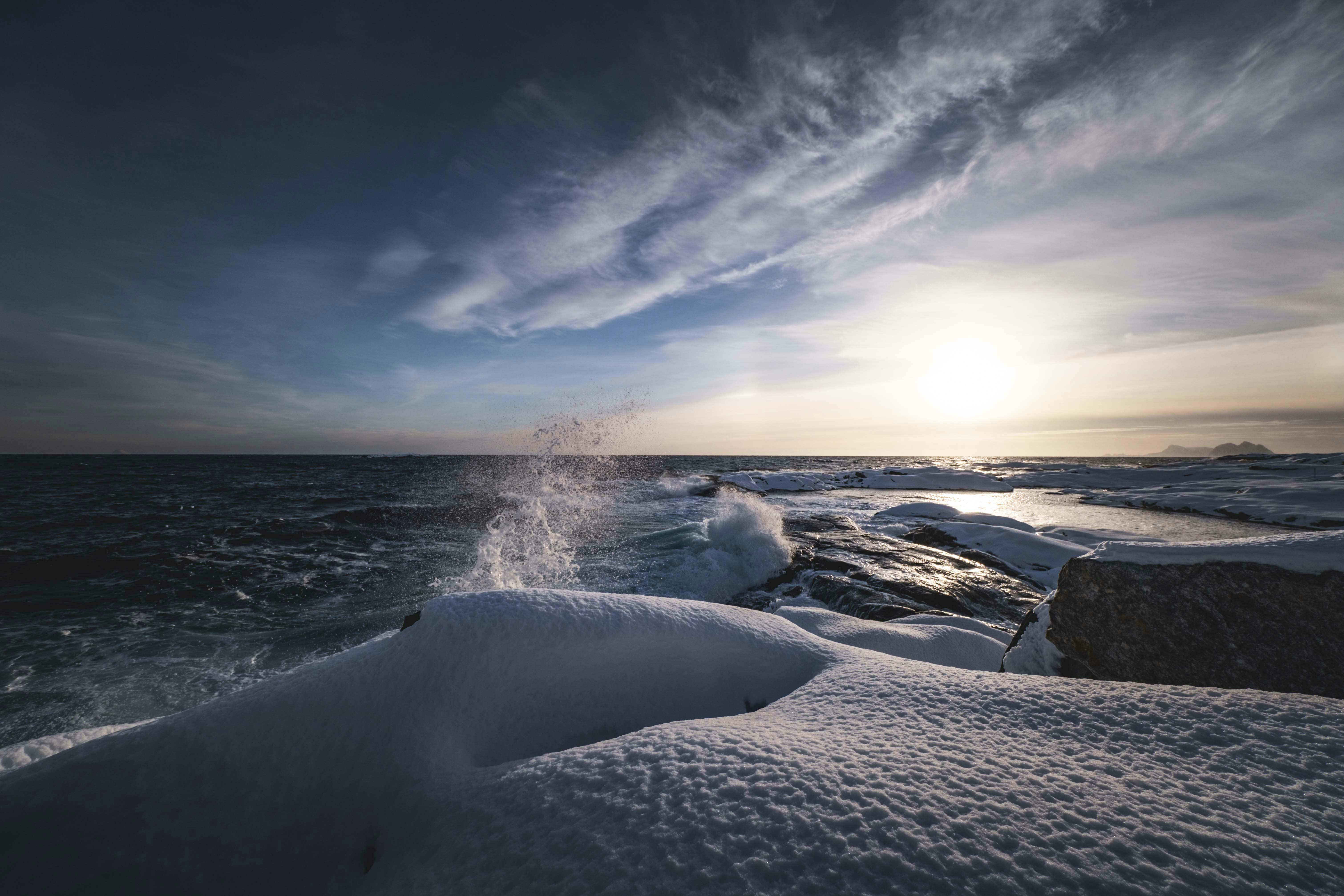 Dramatic Winter Ocean with Snow-Covered Shoreline · Free Stock Photo