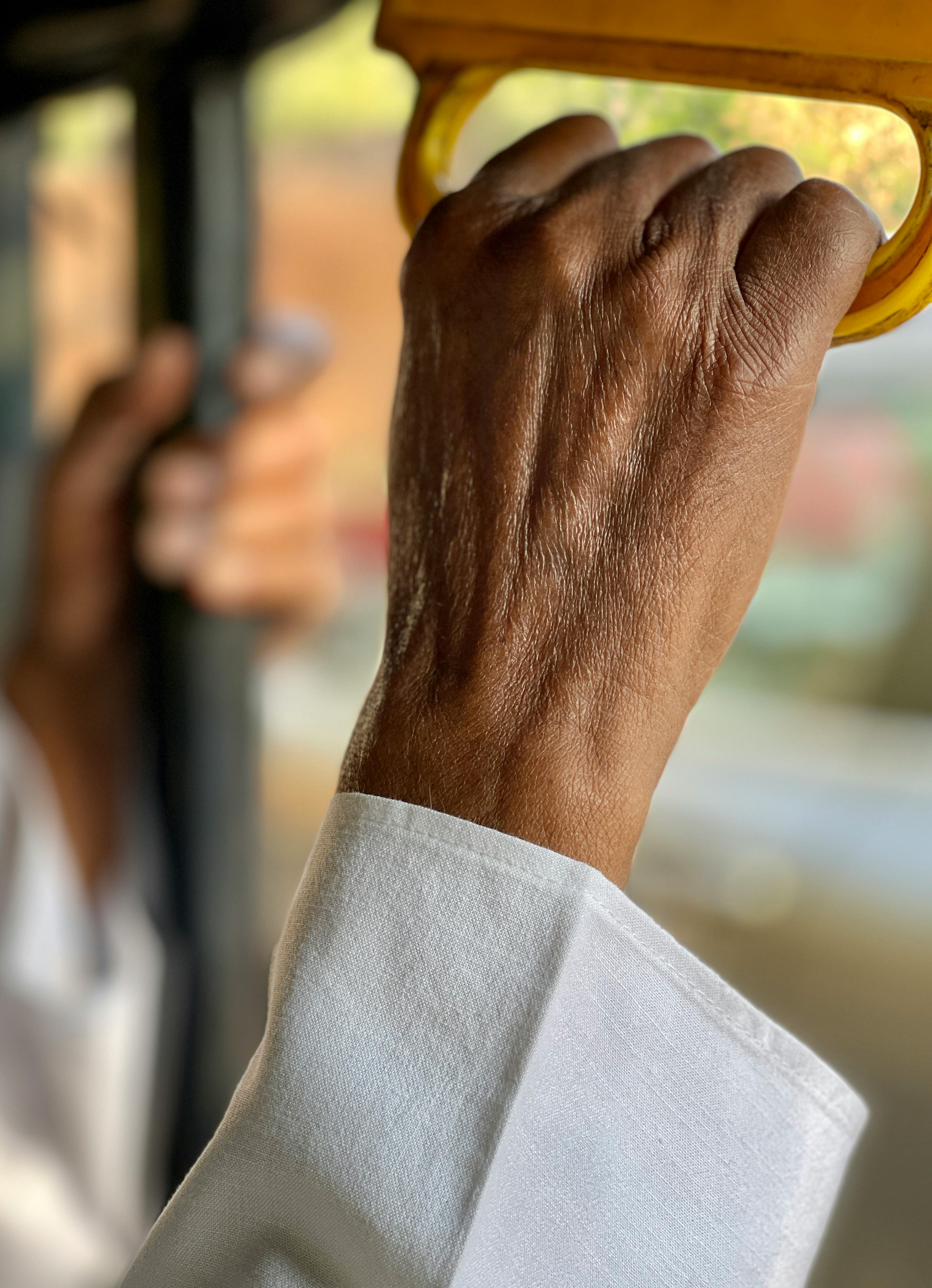 Close-up of Hand Gripping Handle in Vehicle · Free Stock Photo