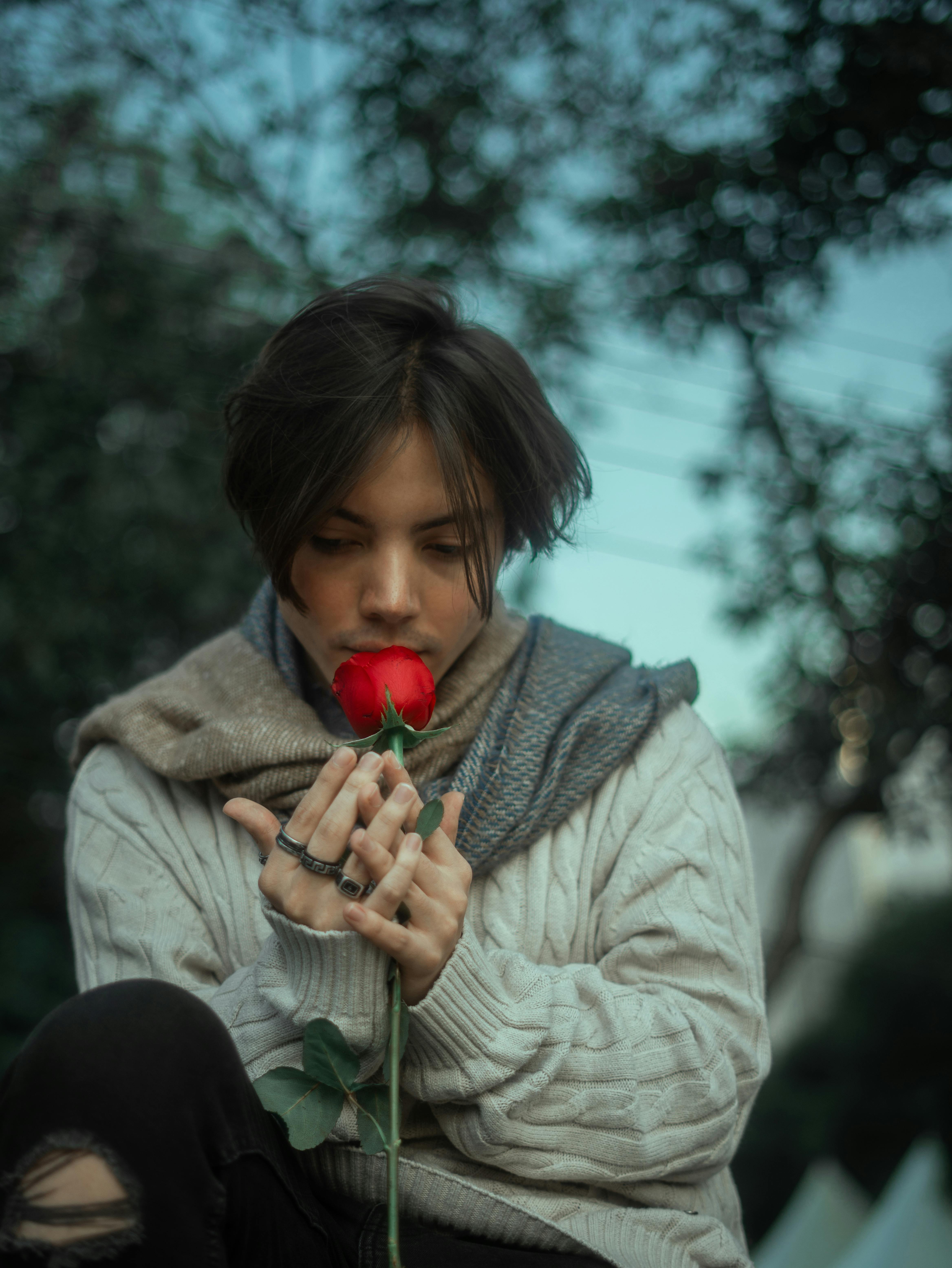 Romantic Portrait of Person Holding Red Rose Outdoors · Free Stock Photo