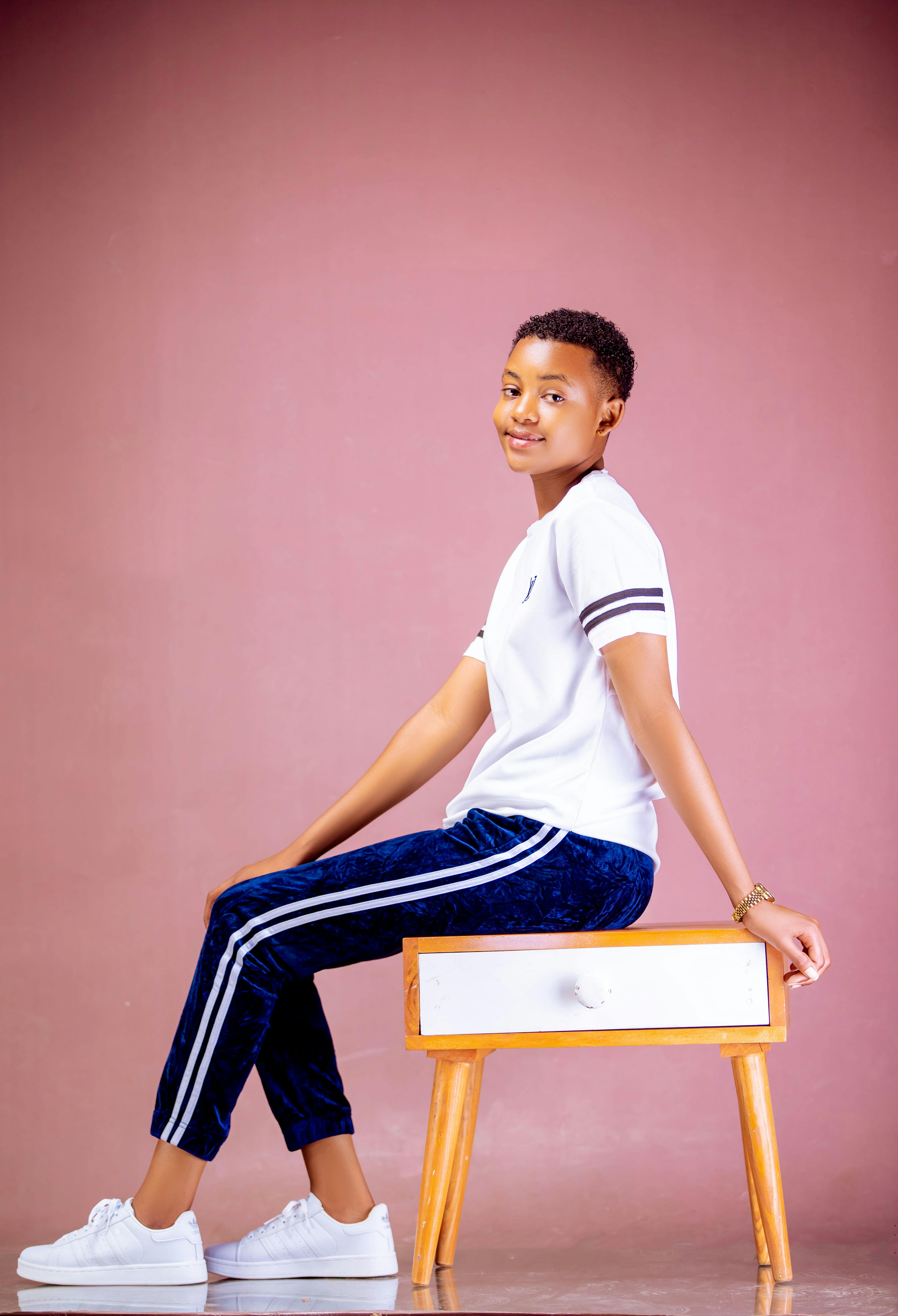Teenager Sitting on Stool in Stylish Outfit · Free Stock Photo