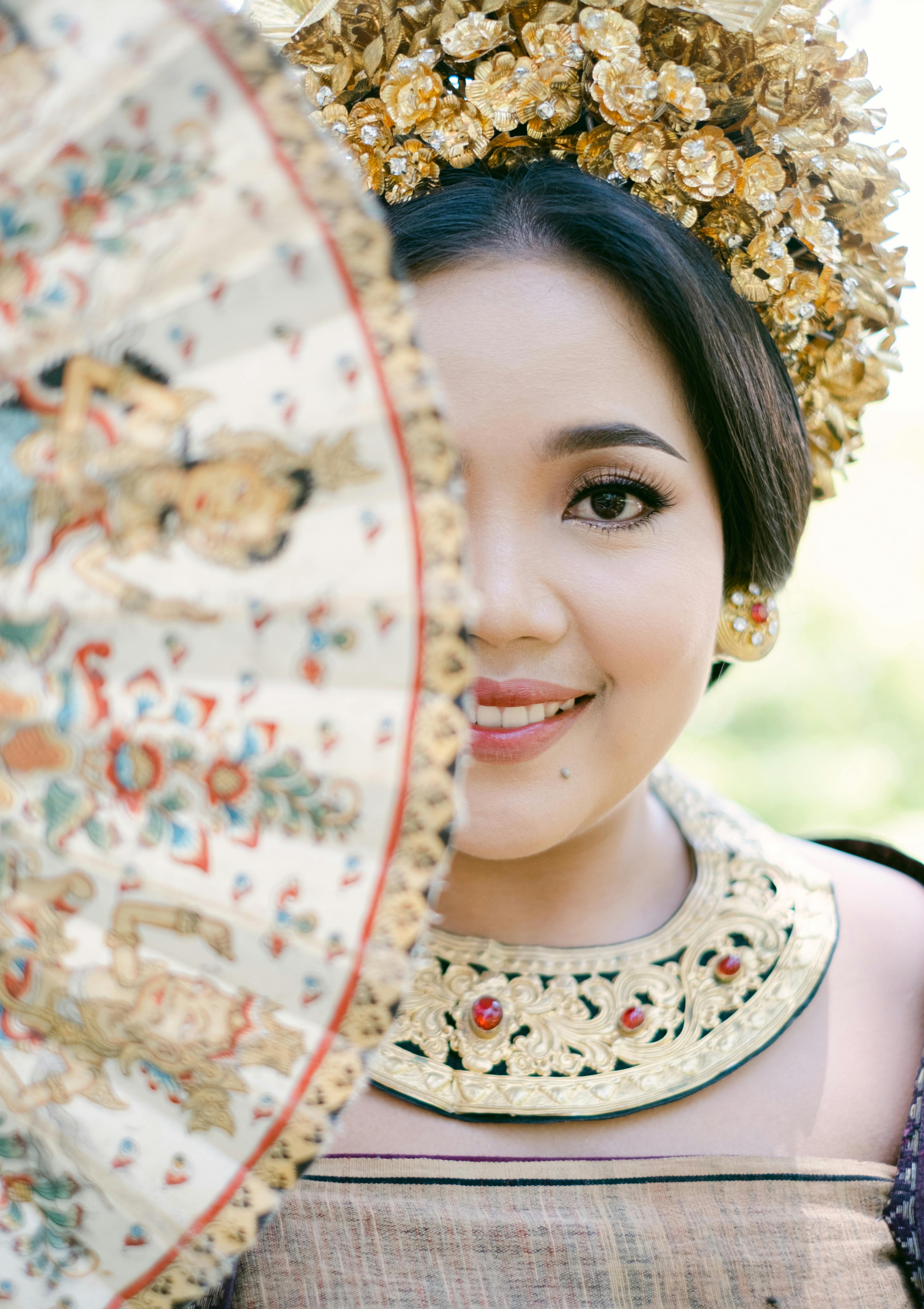 Traditional Balinese Attire and Ornate Fan Portrait · Free Stock Photo