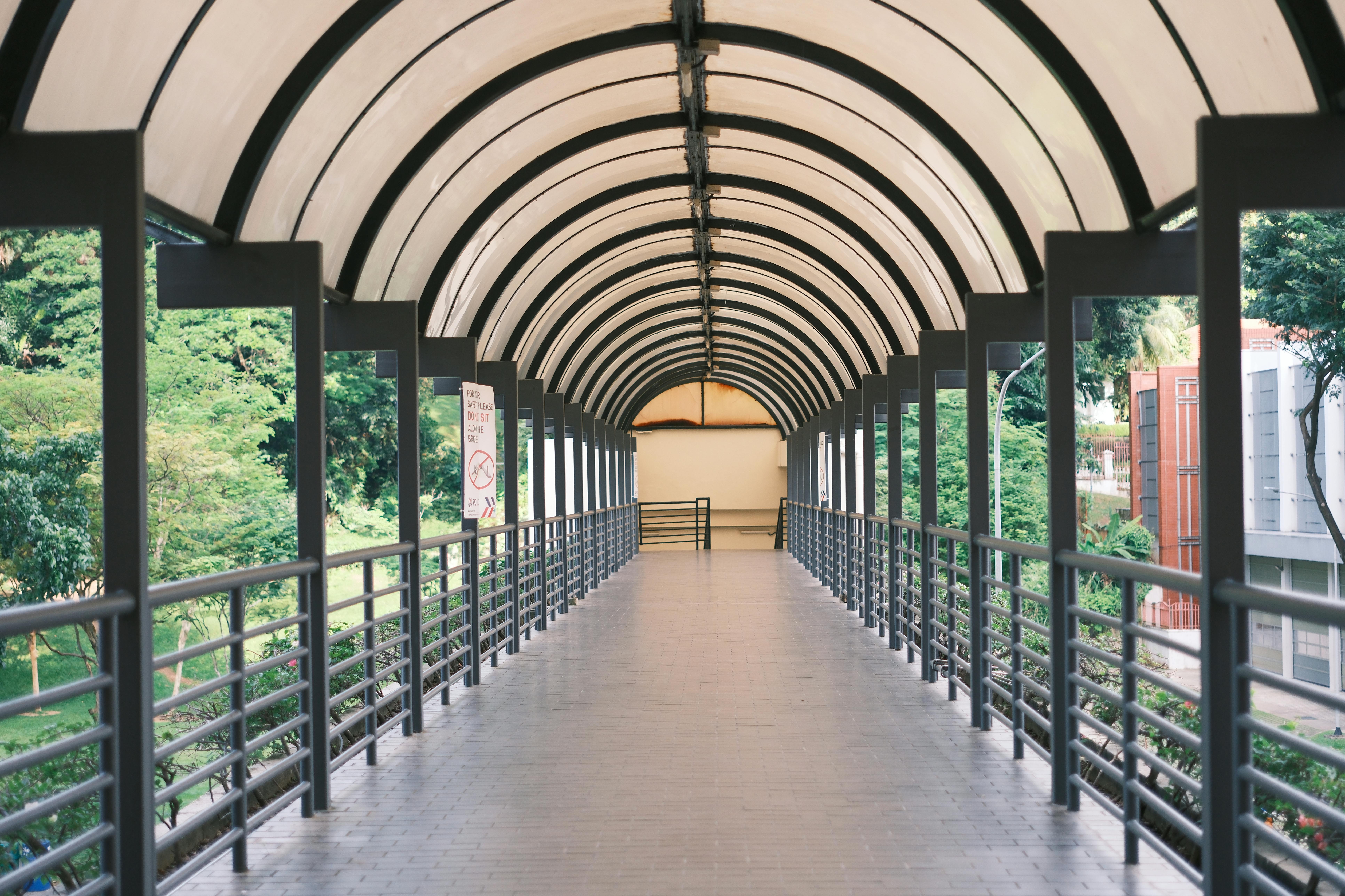 Covered Pedestrian Bridge with Metal Arches · Free Stock Photo