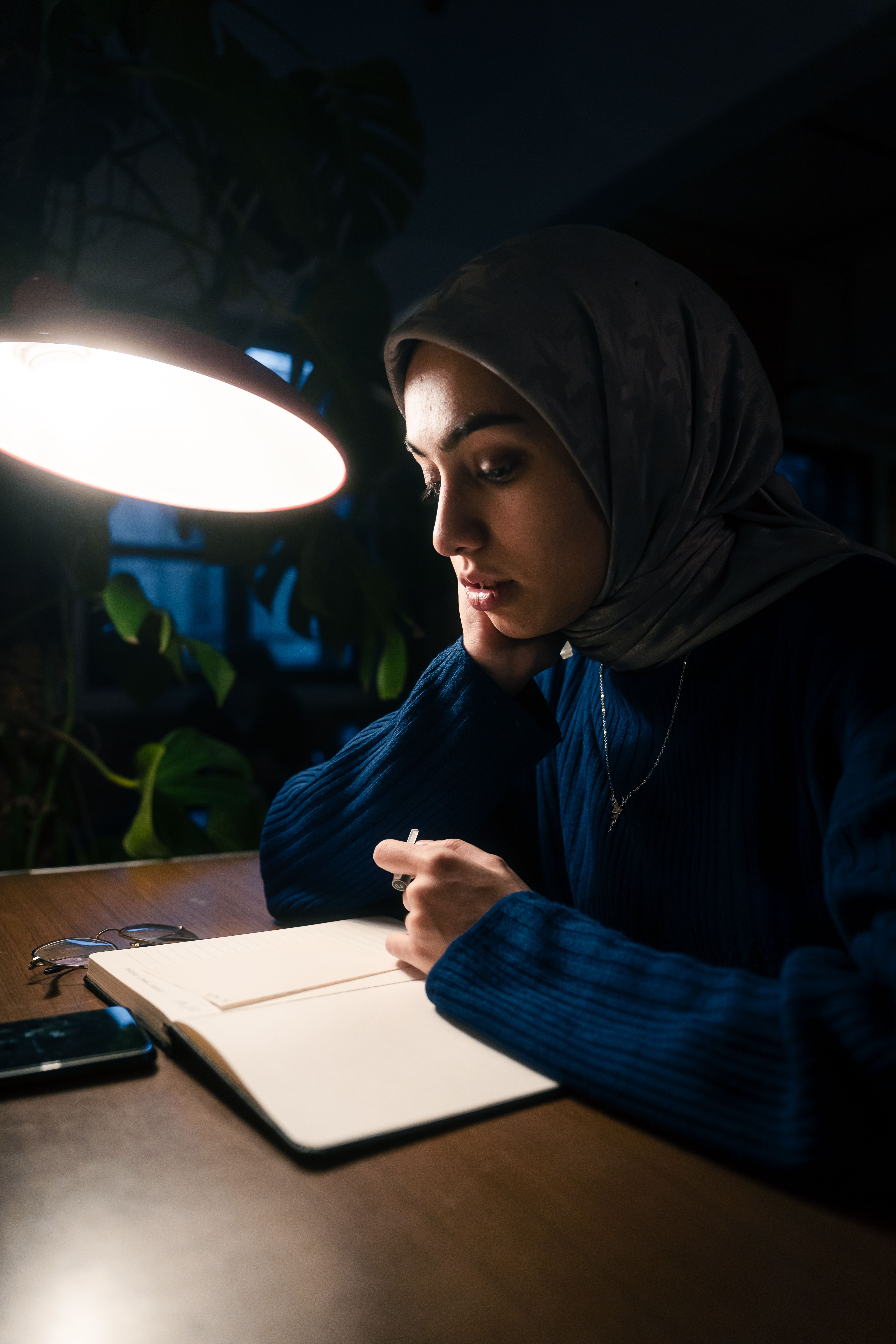Young Woman Studying at Night with Notebook · Free Stock Photo