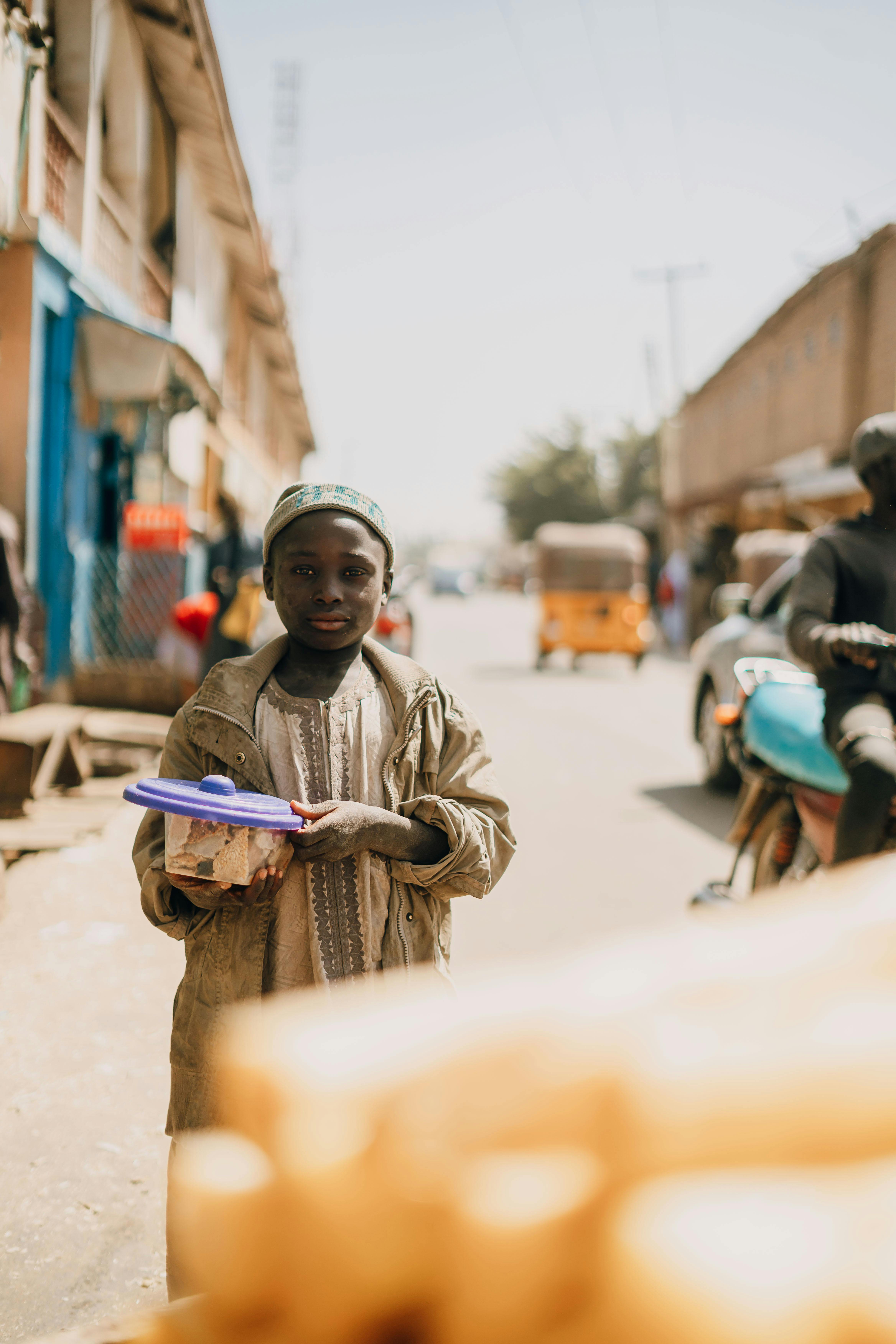 Street Scene with Child Vendor in Urban Setting · Free Stock Photo
