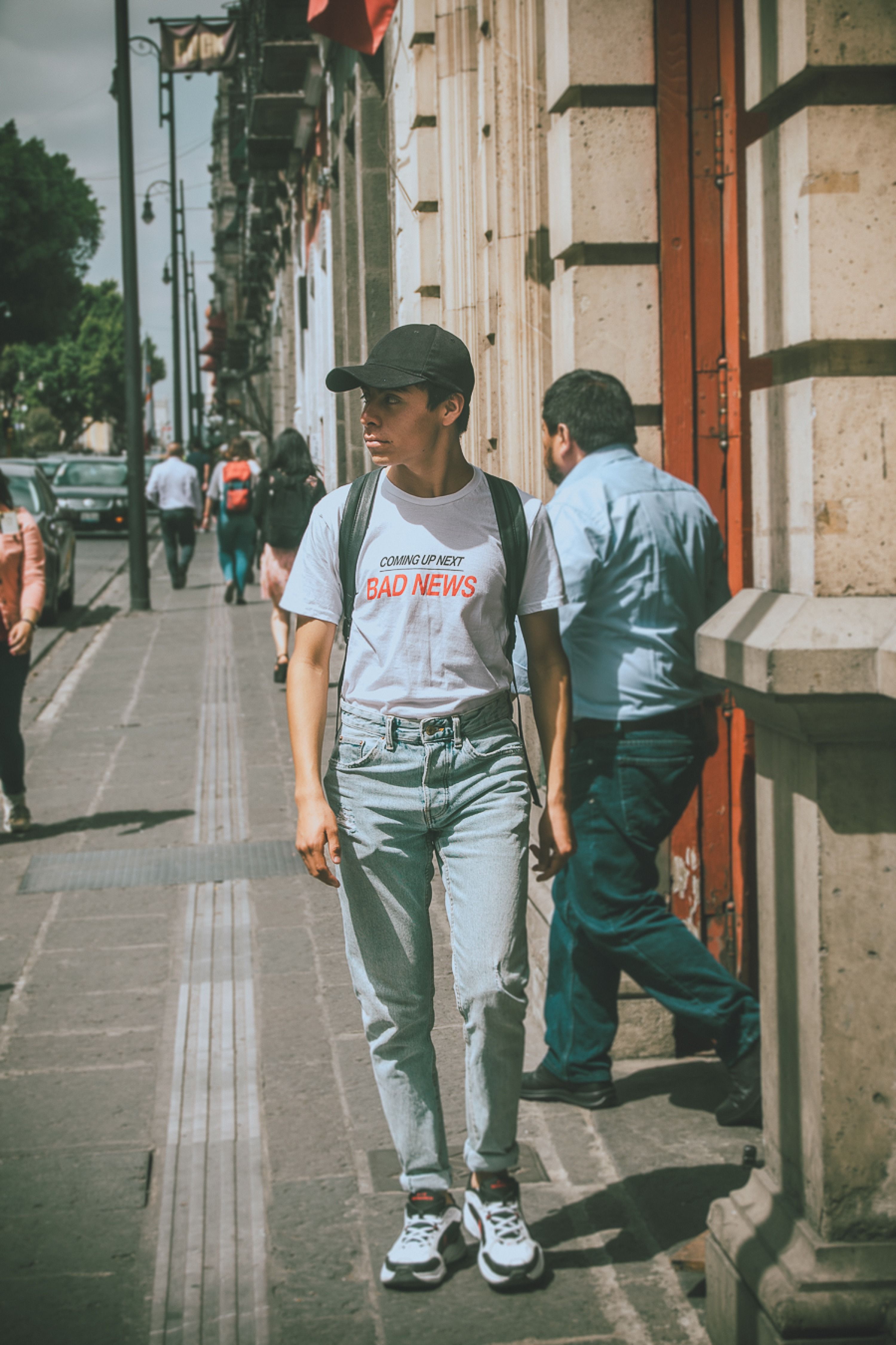 Young Adult Walking on Urban Street Edge · Free Stock Photo