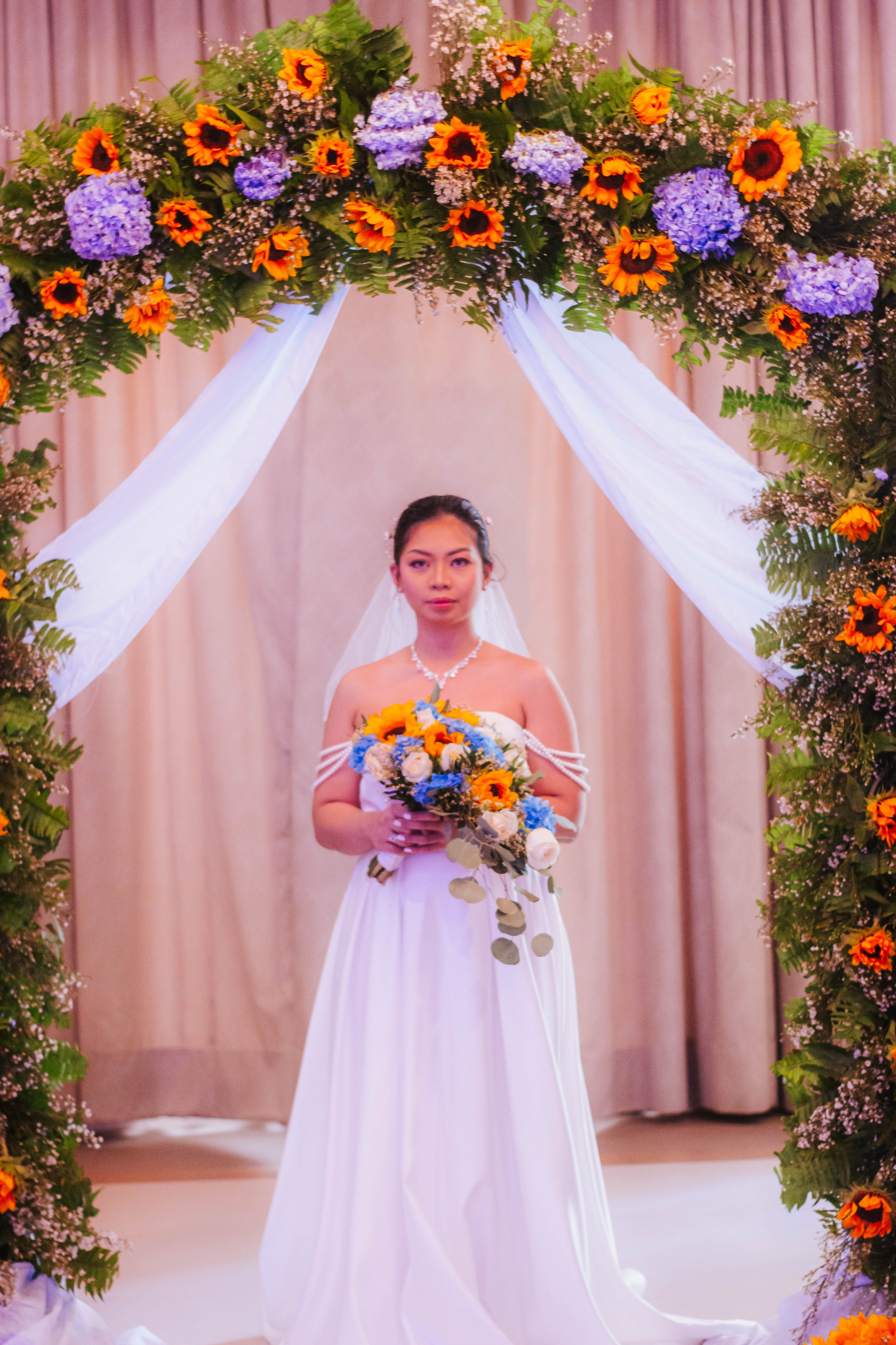 Bride under floral wedding arch with sunflowers · Free Stock Photo