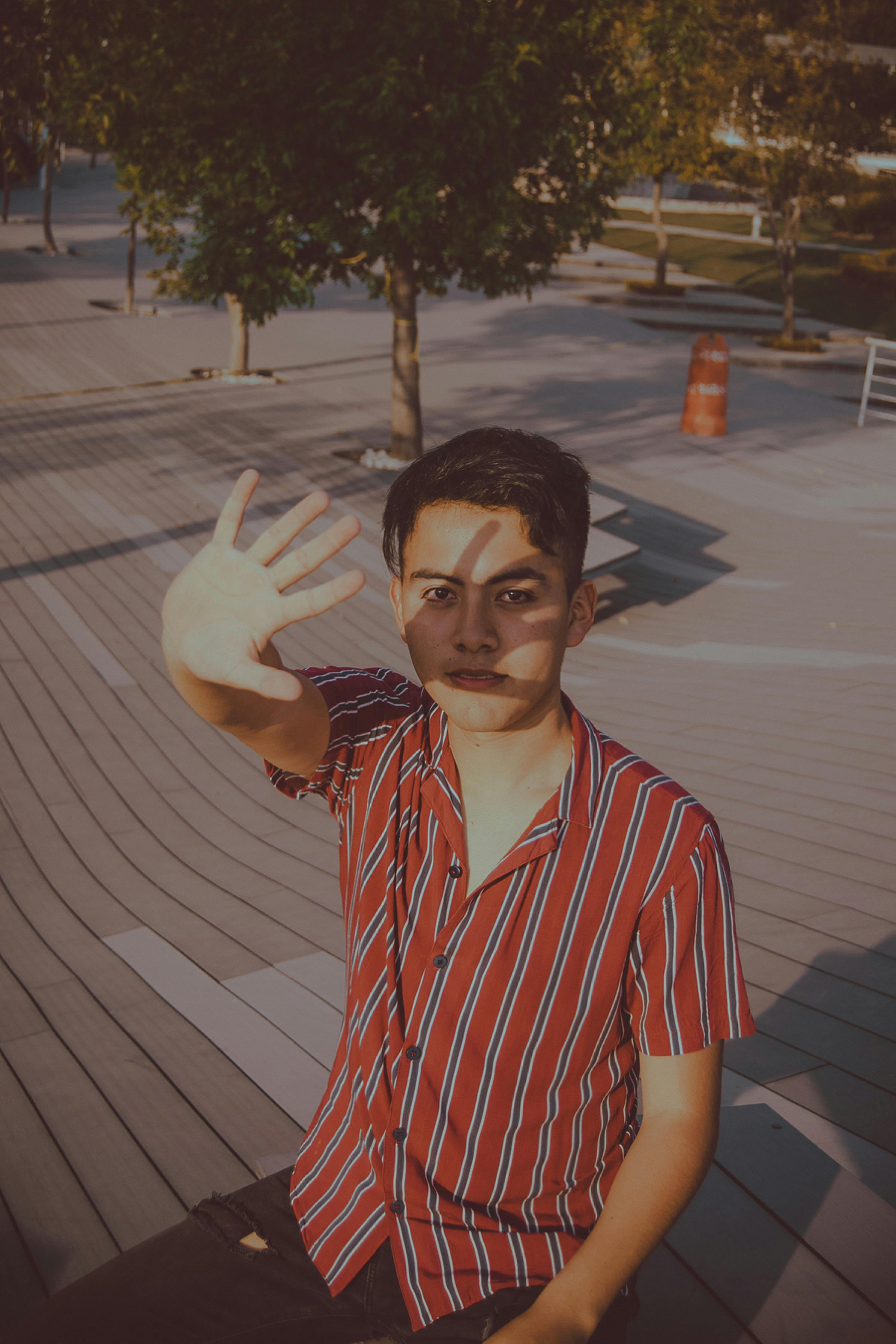 Outdoor Portrait of Young Man Blocking Sunlight · Free Stock Photo