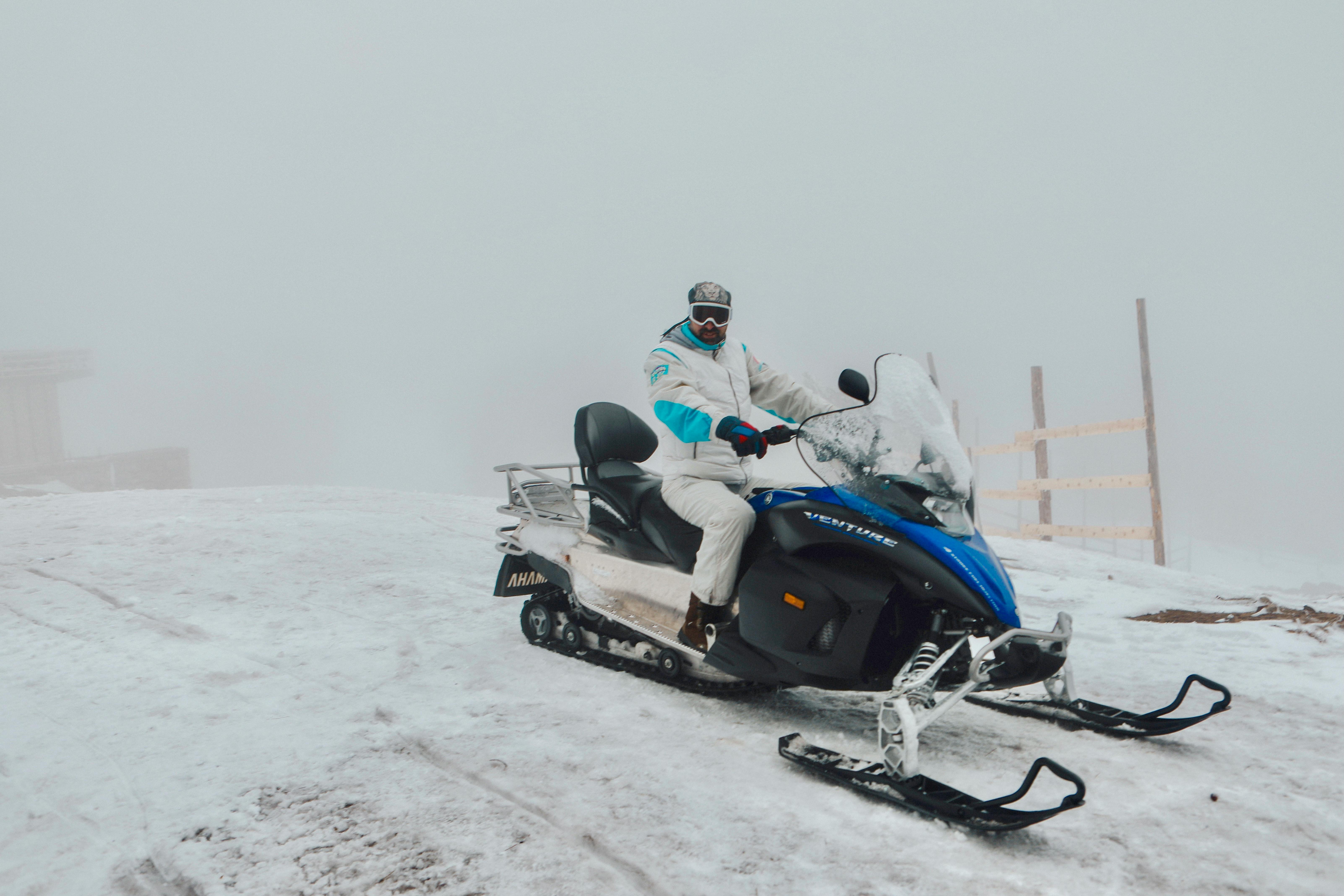 Person Riding Snowmobile in a Foggy Winter Landscape · Free Stock Photo