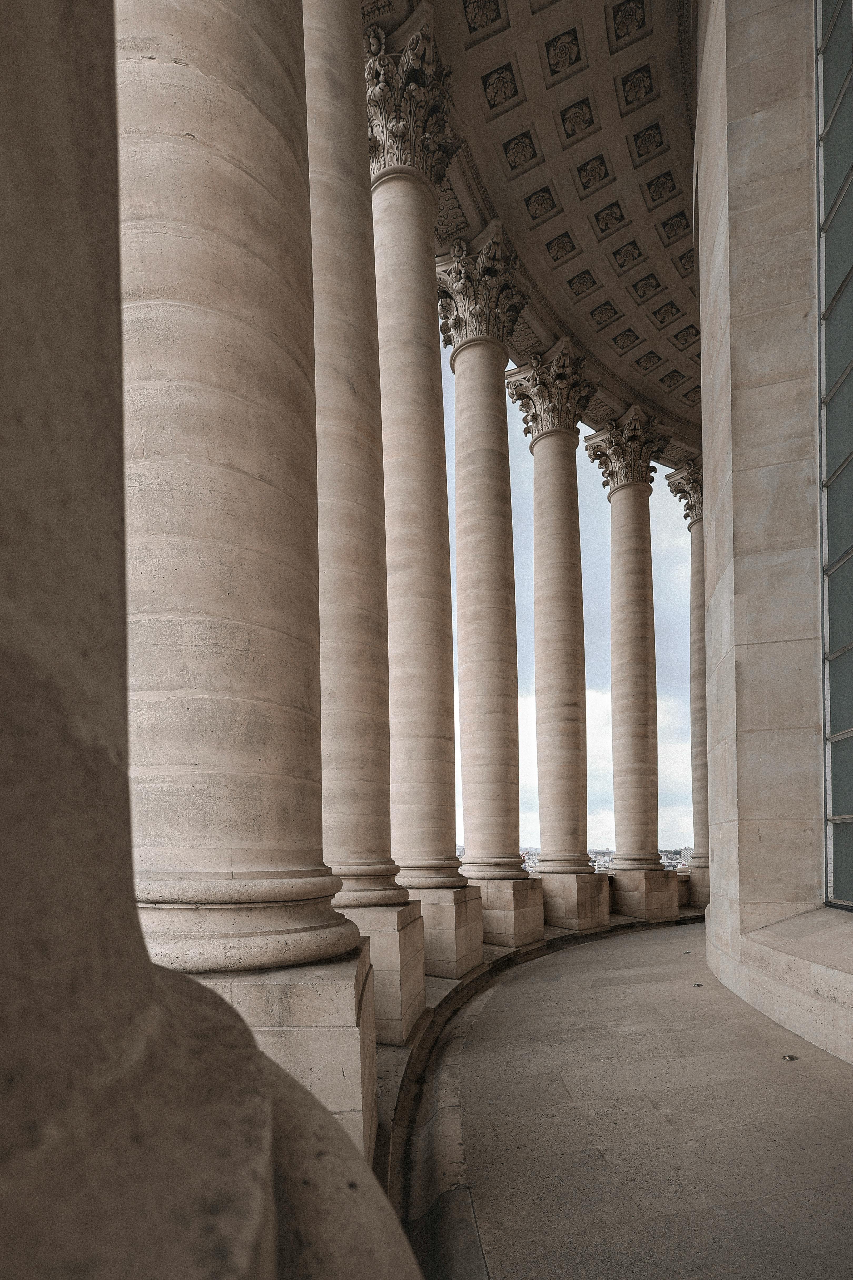 Narrow building passageway with arch columns · Free Stock Photo