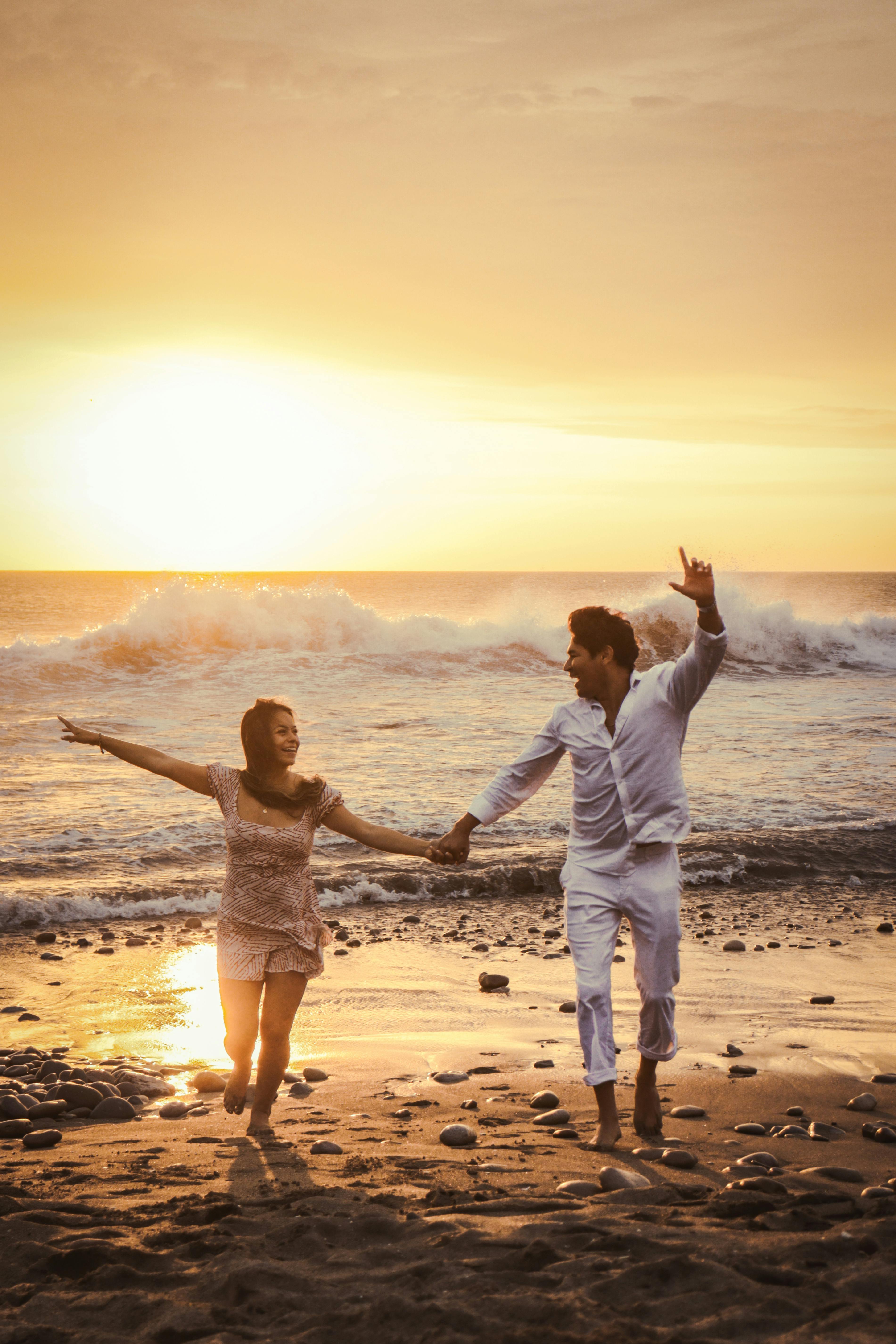 Romantic Couple Enjoying a Sunset Beach Walk · Free Stock Photo