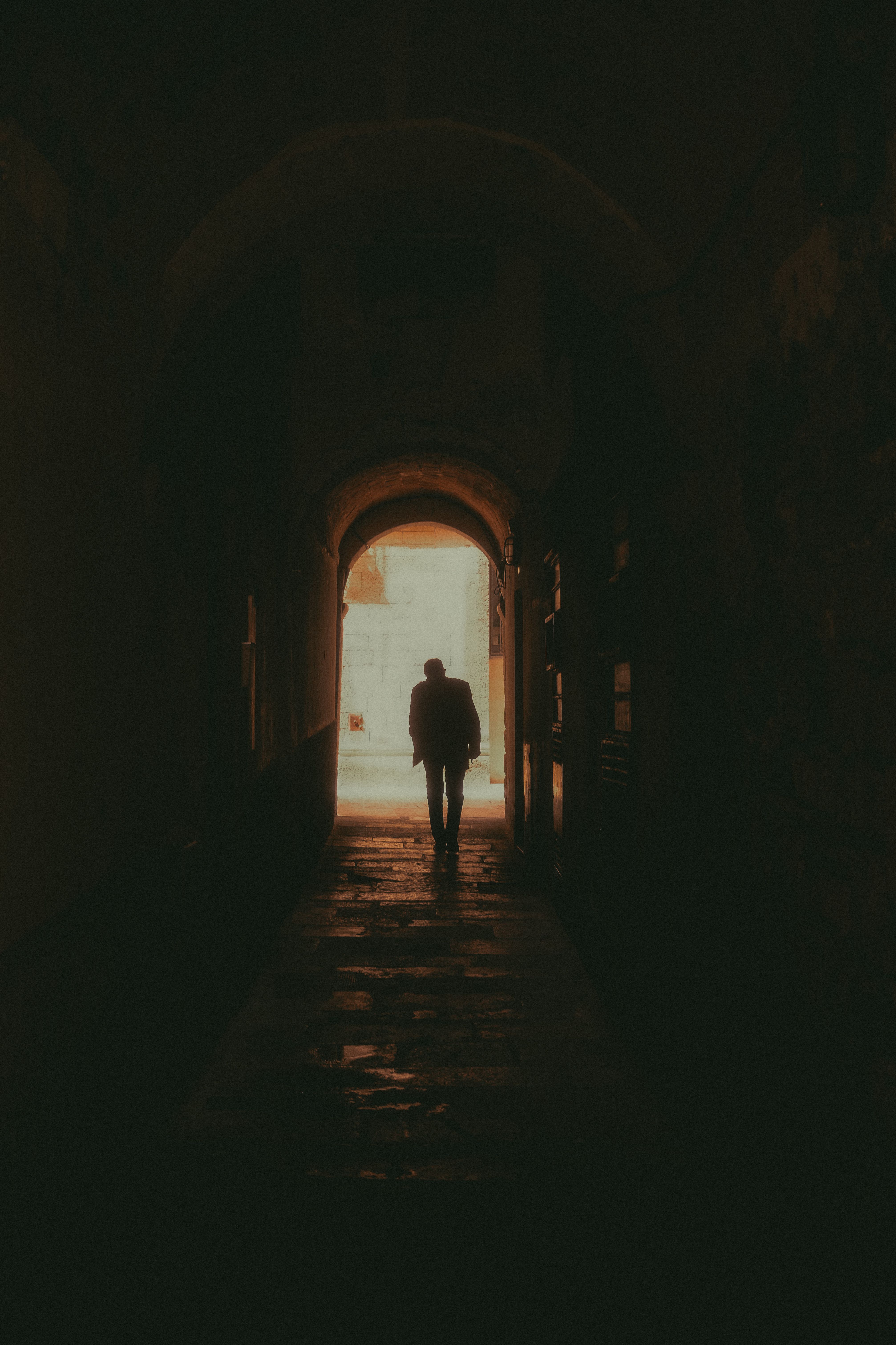 Mysterious Figure Walking Through Darkened Alley · Free Stock Photo