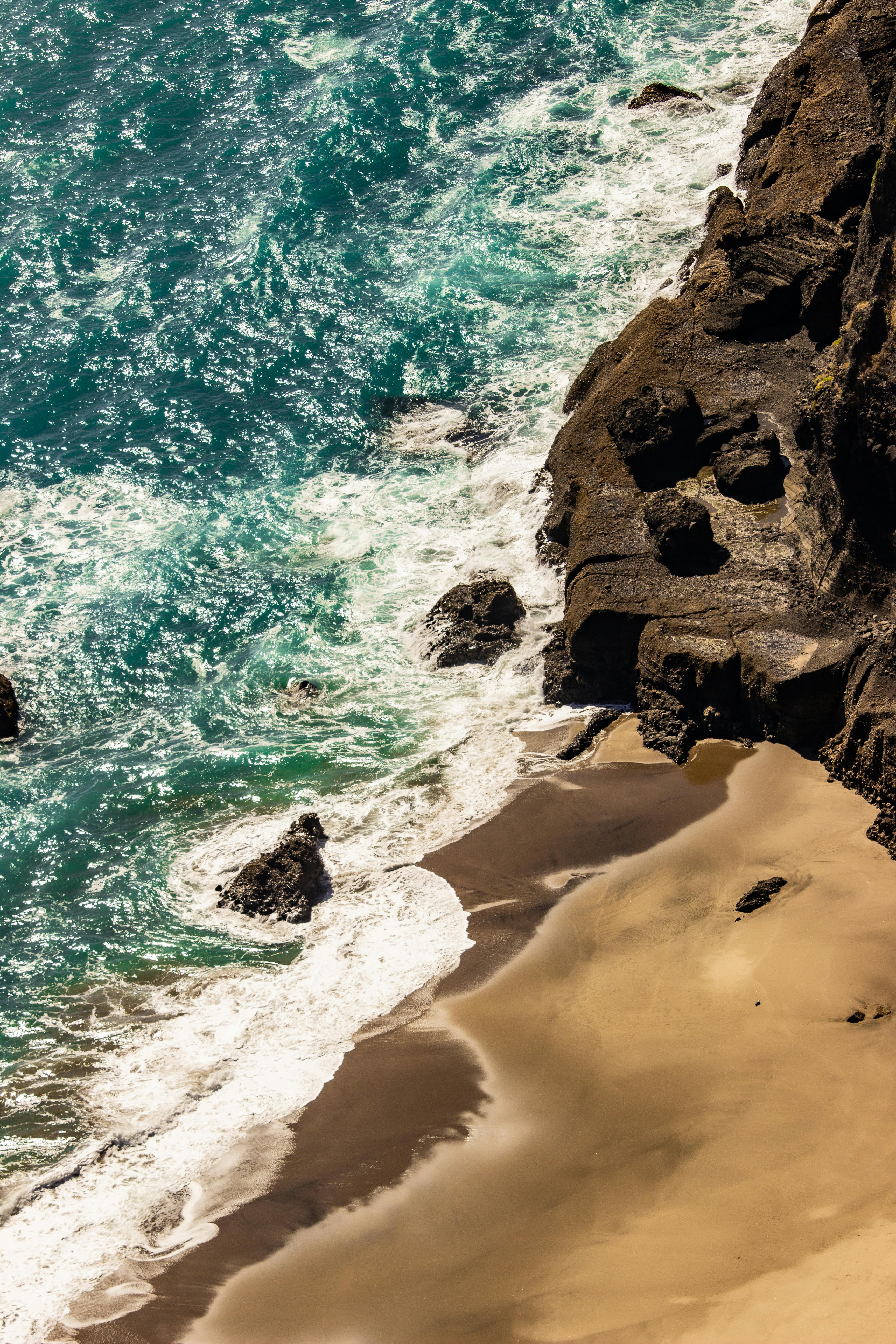 Dramatic Cliffside Beach with Turquoise Waves · Free Stock Photo