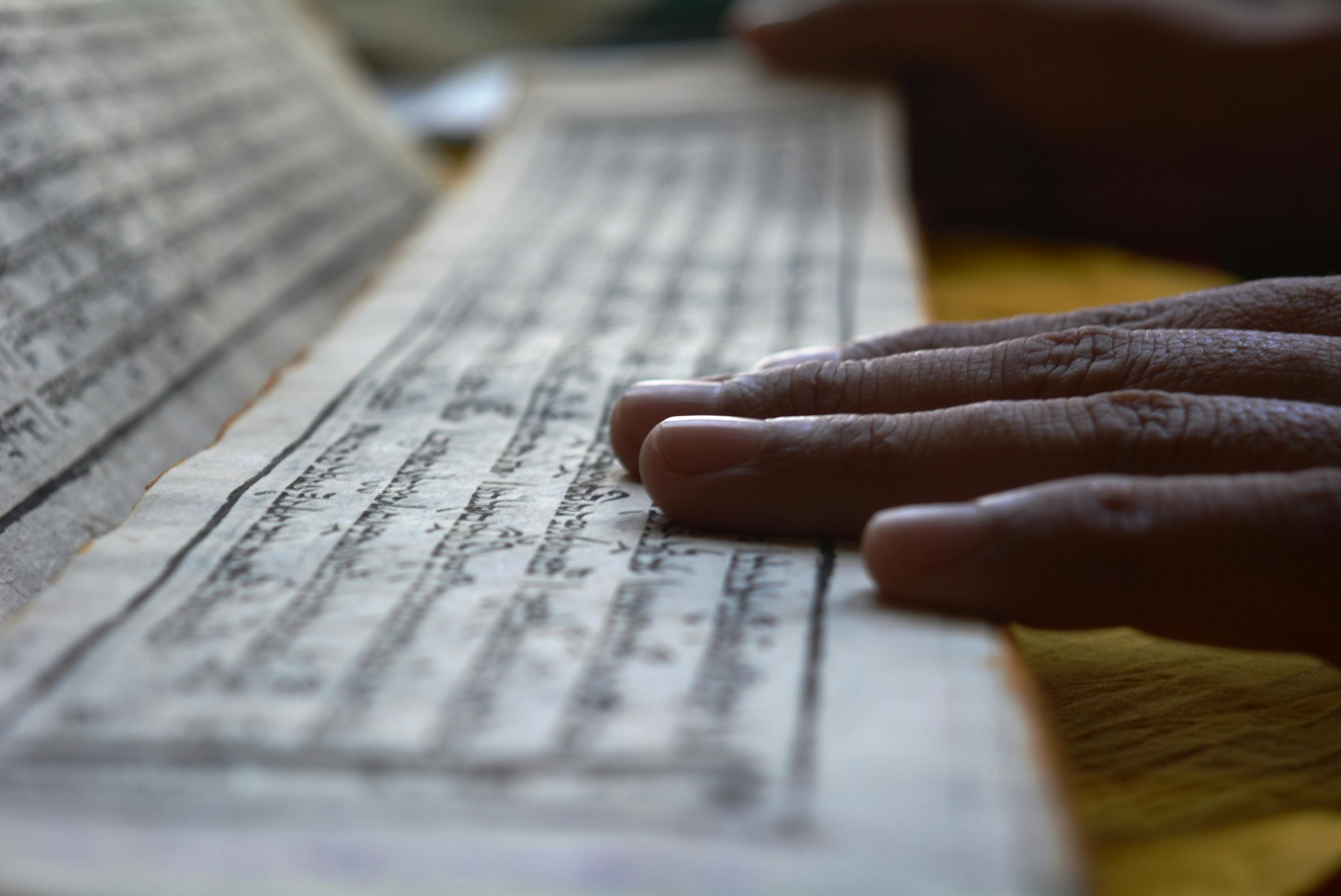 Close-up of Hands on Sacred Buddhist Scripture · Free Stock Photo