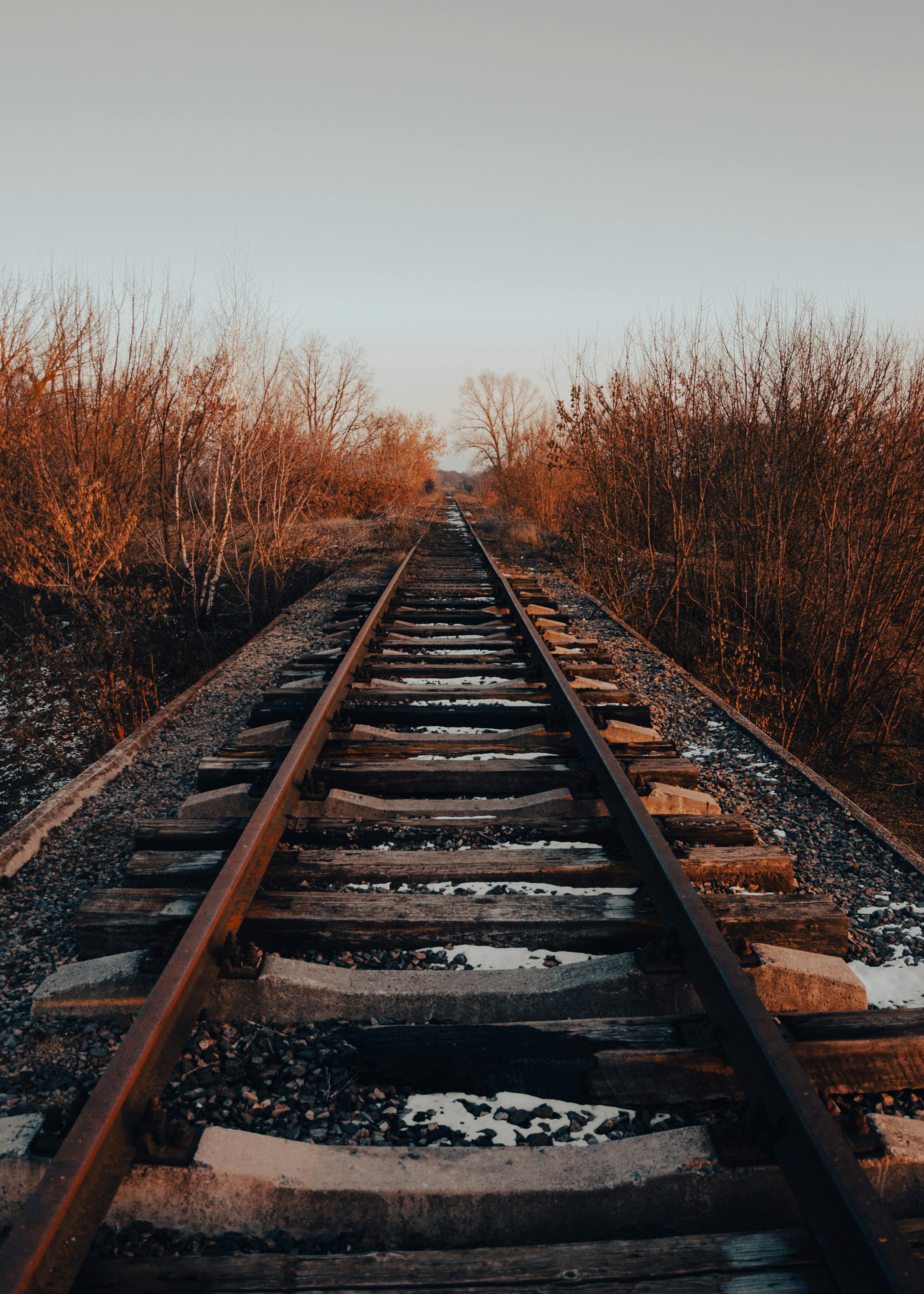 Rustic railway track in serene autumn landscape · Free Stock Photo