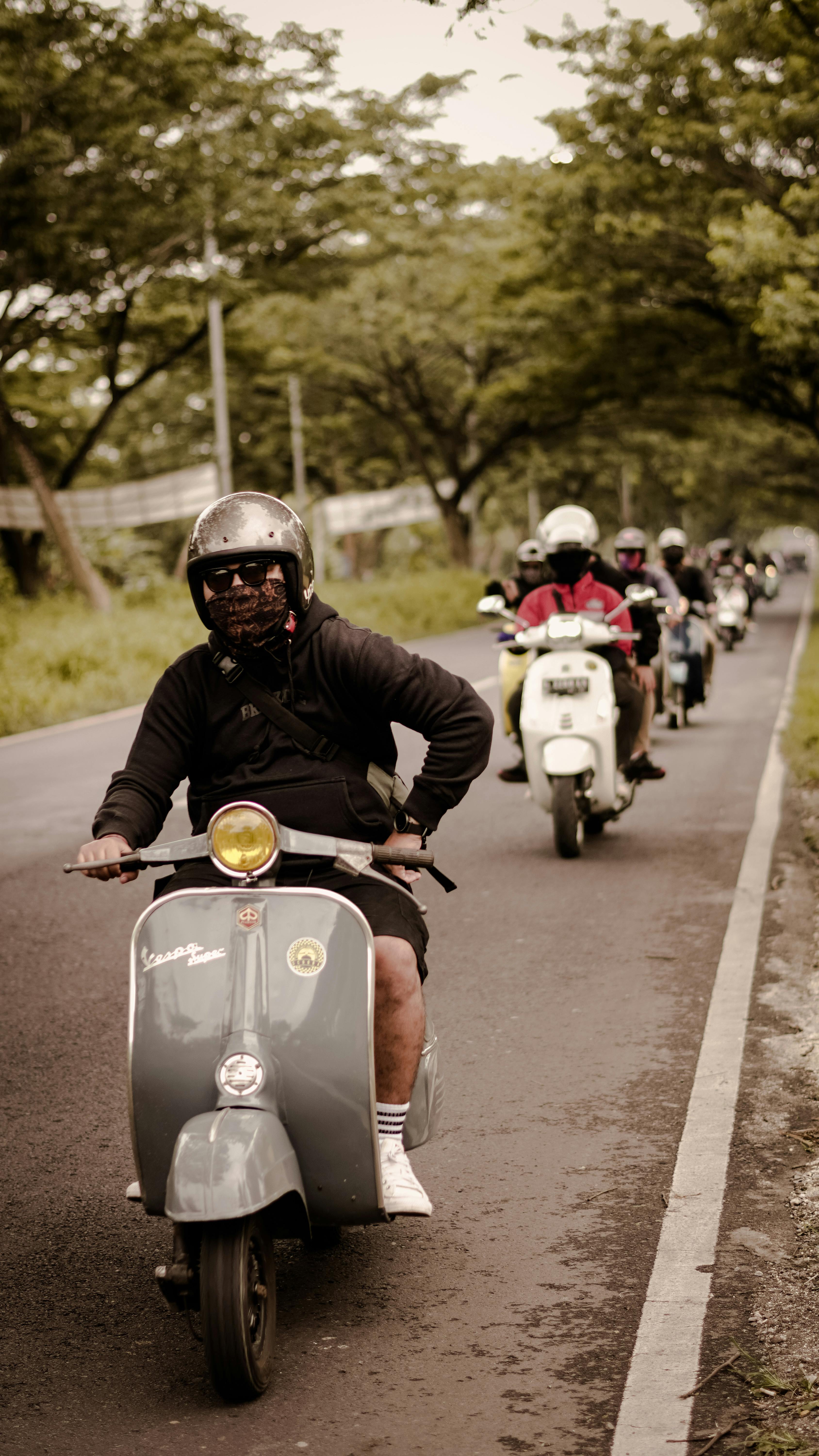 Group Riding Classic Vespas on Scenic Road · Free Stock Photo
