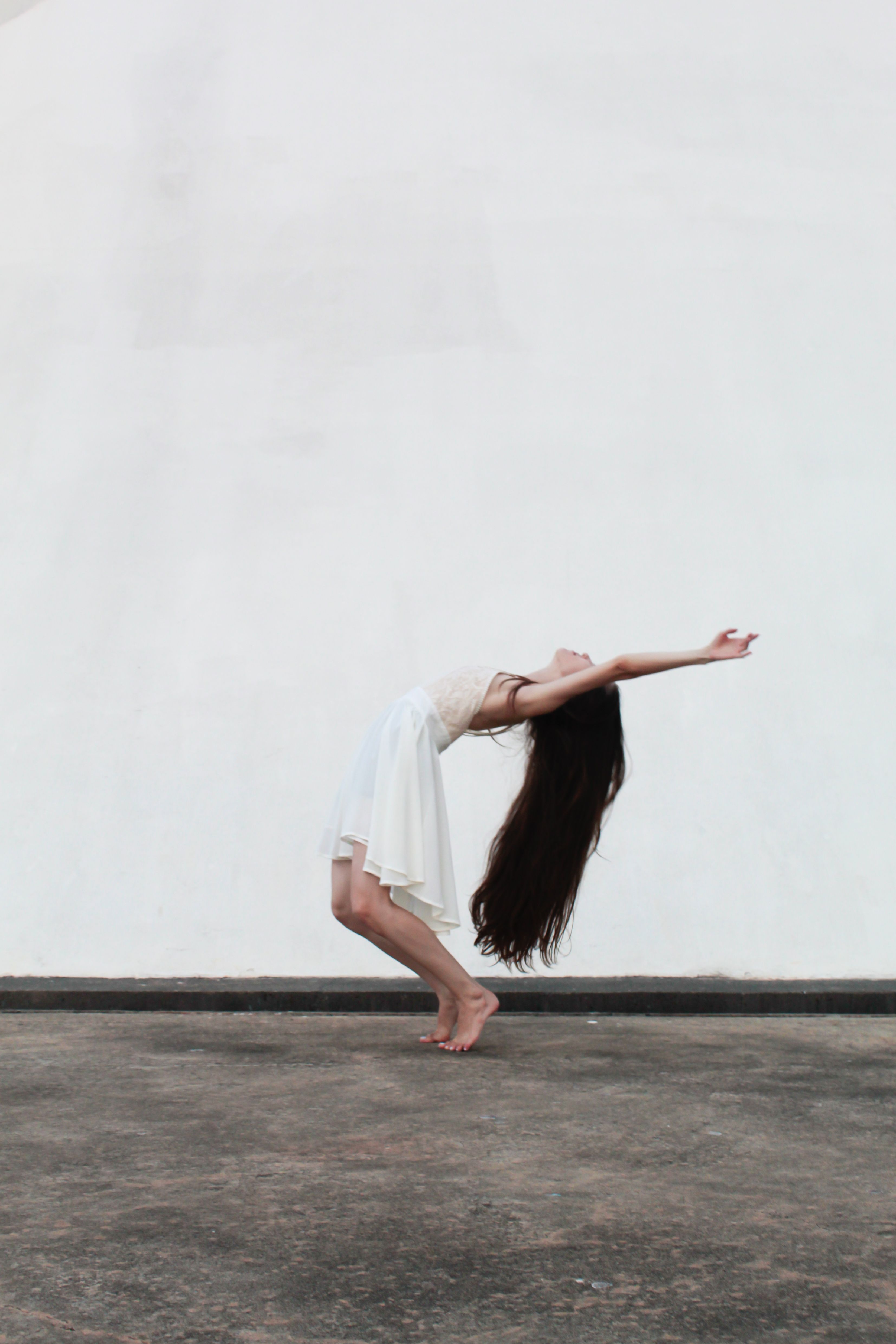 Dynamic Pose of a Woman Against Minimalist Background · Free Stock Photo