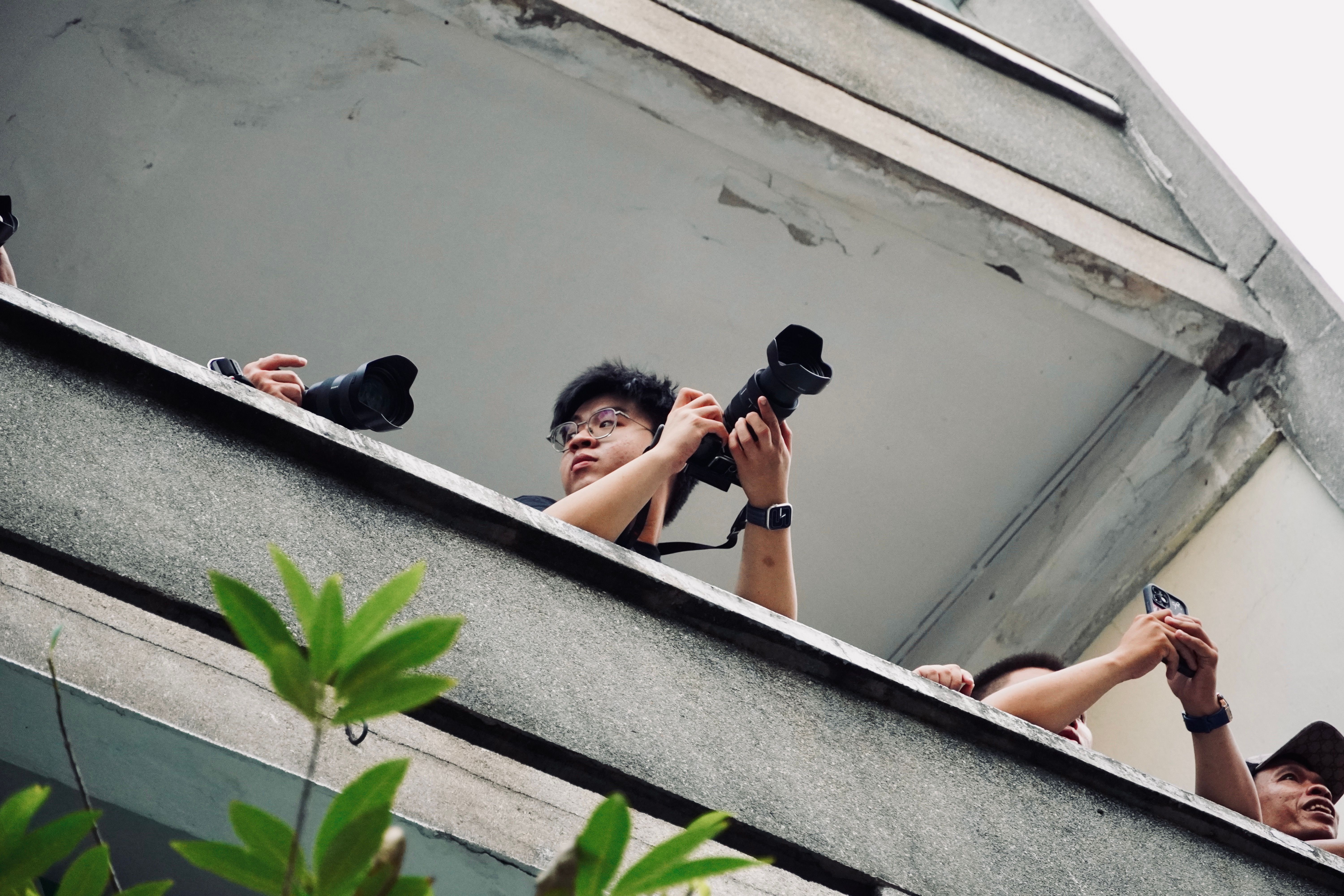 Photographers on Balcony Capturing Moments · Free Stock Photo