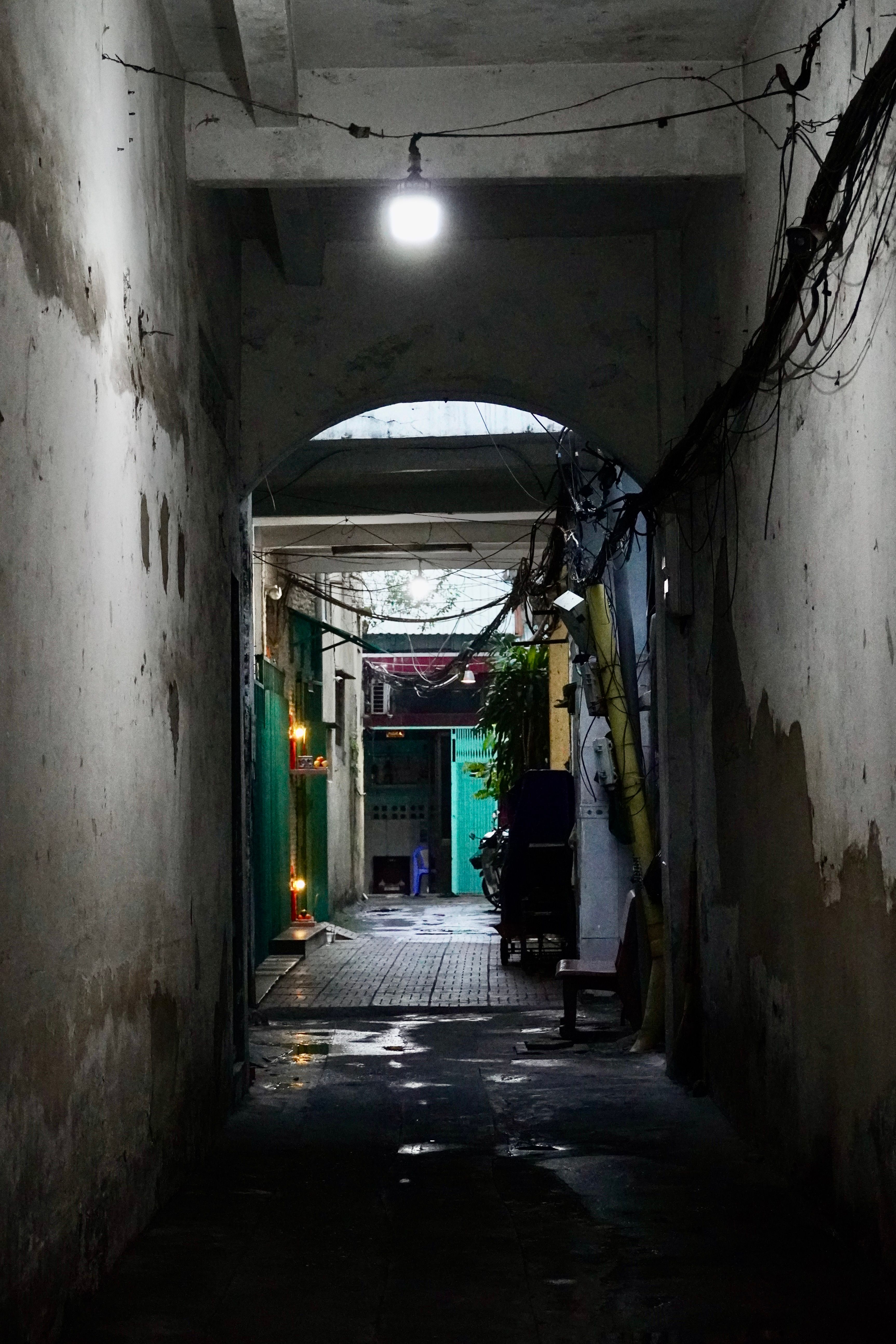Narrow Urban Alleyway with Overhead Lighting · Free Stock Photo