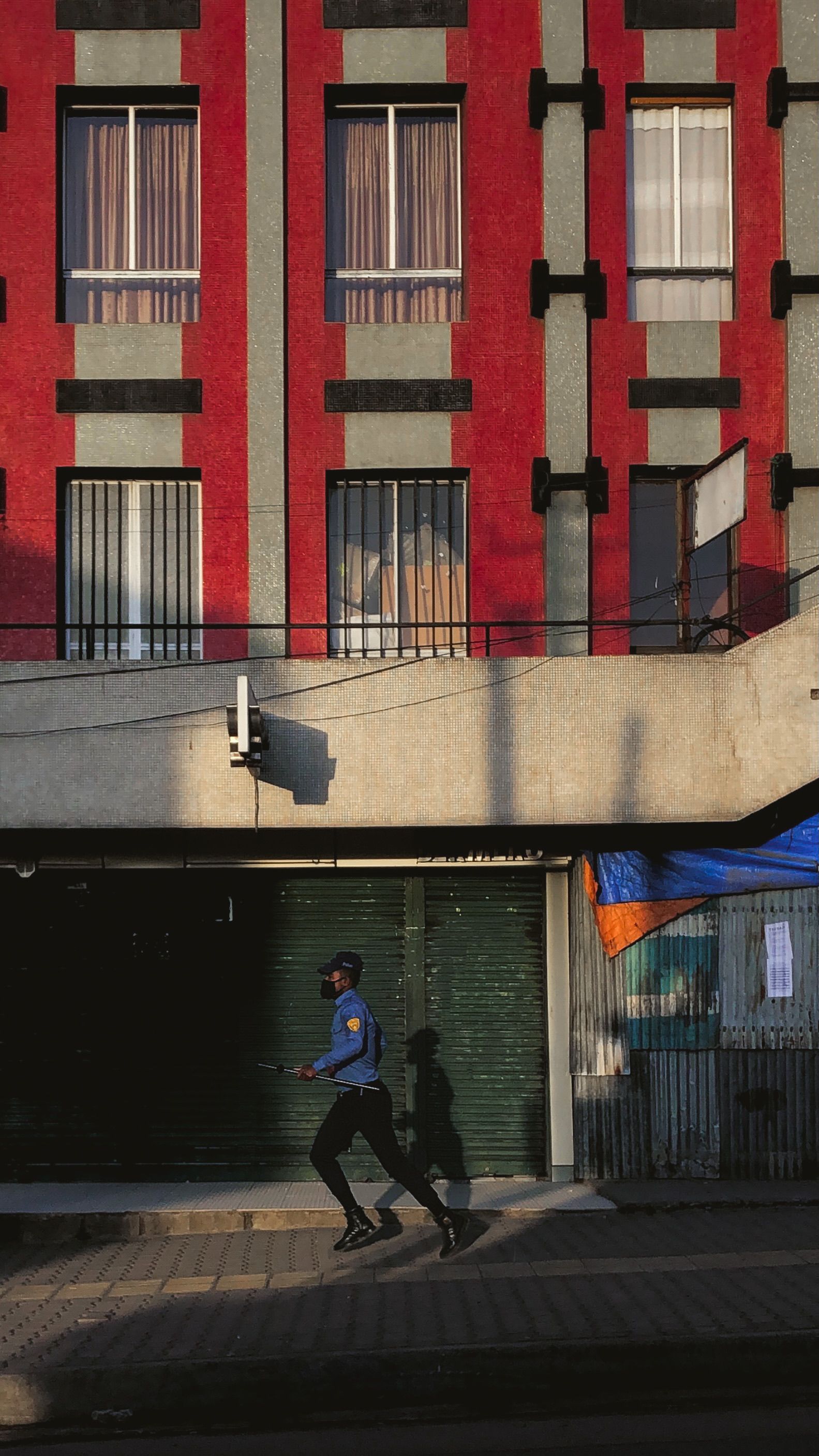 City Street Security Guard Against Colorful Building · Free Stock Photo