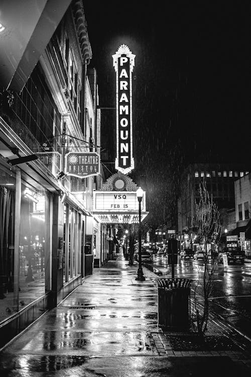 театр Paramount в ночной сцене на улице Rainy Street · Бесплатные