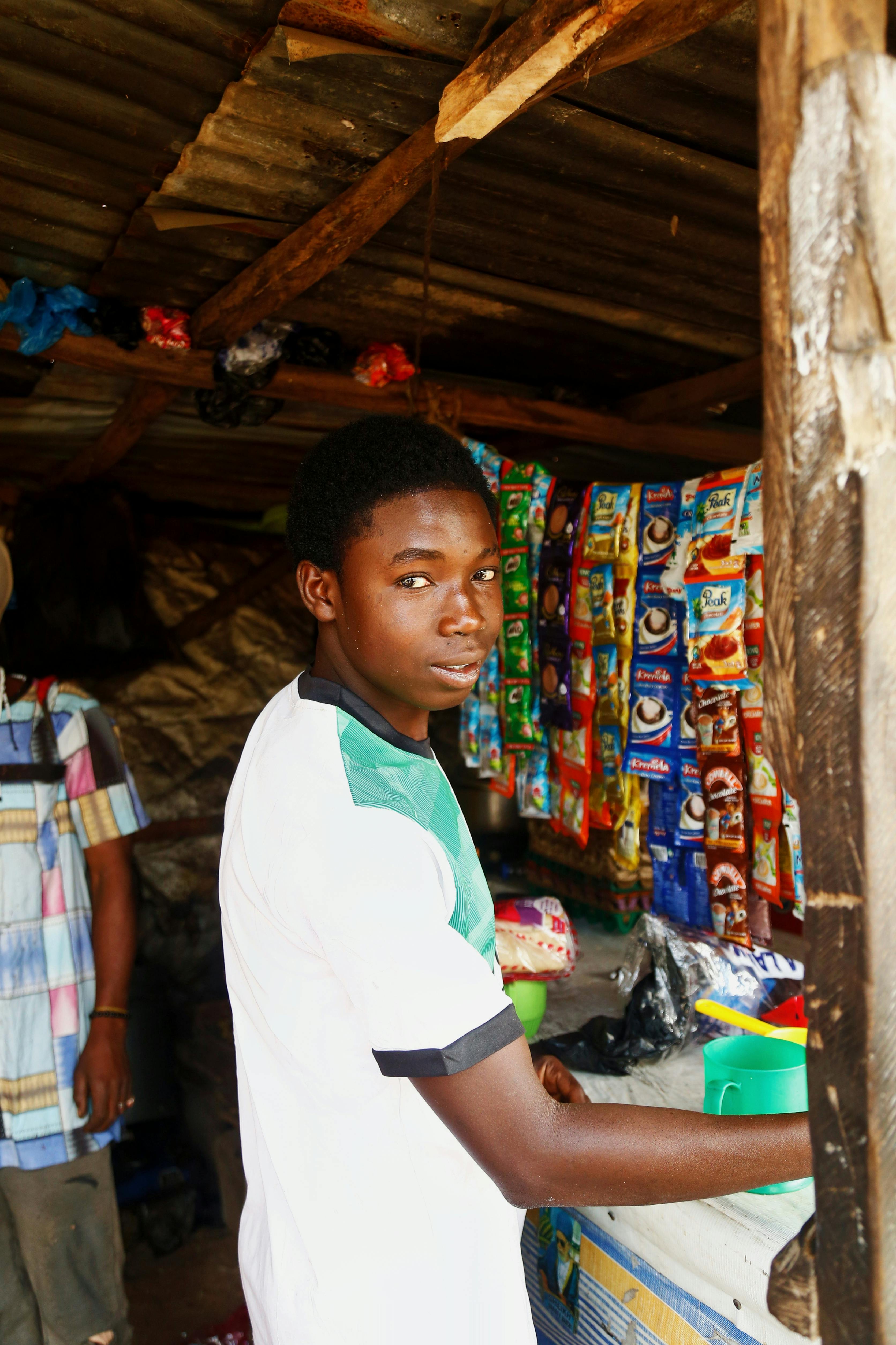 Young Man at Local Abuja Market Stall · Free Stock Photo