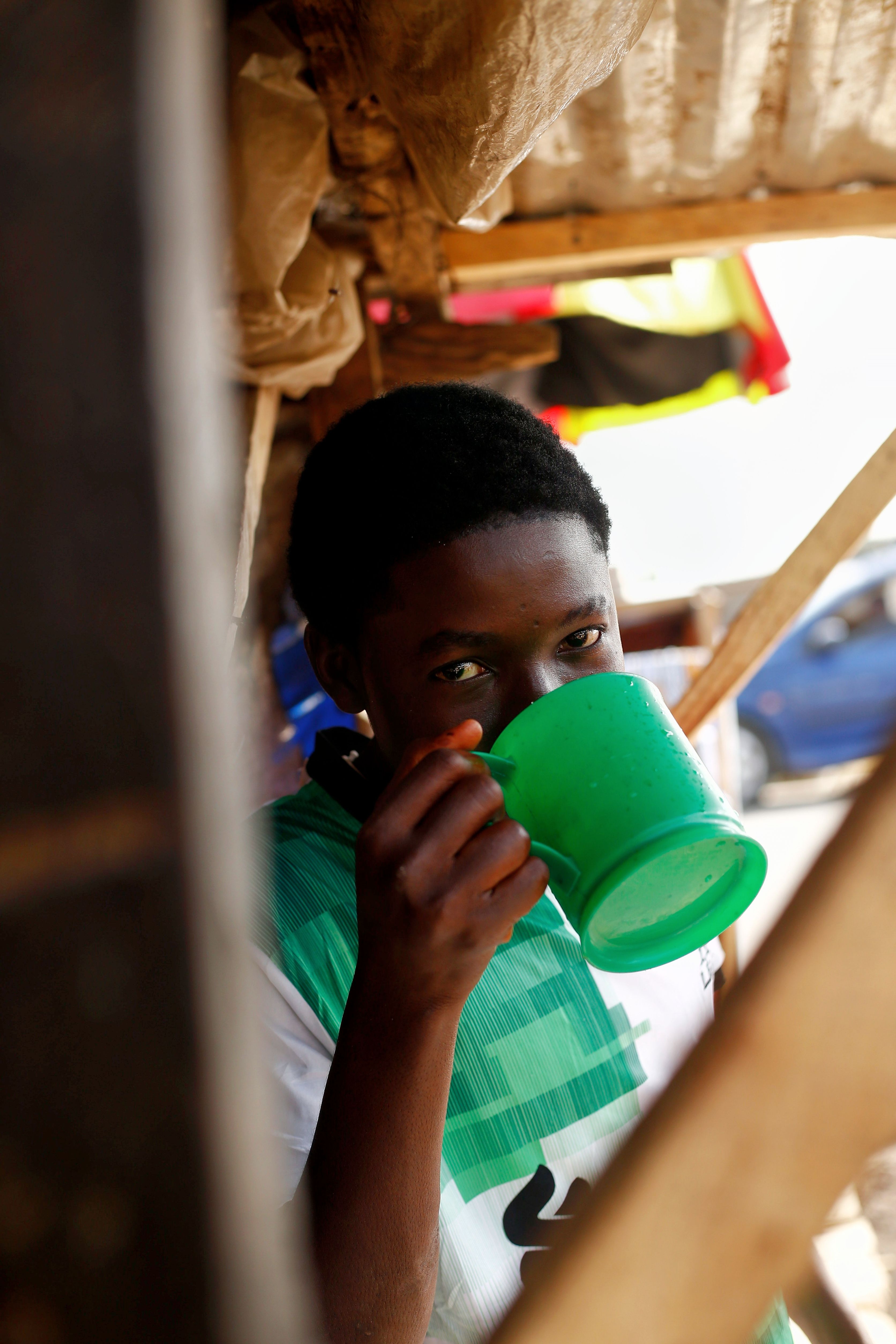 Young Person Drinking from Green Cup Outdoors · Free Stock Photo