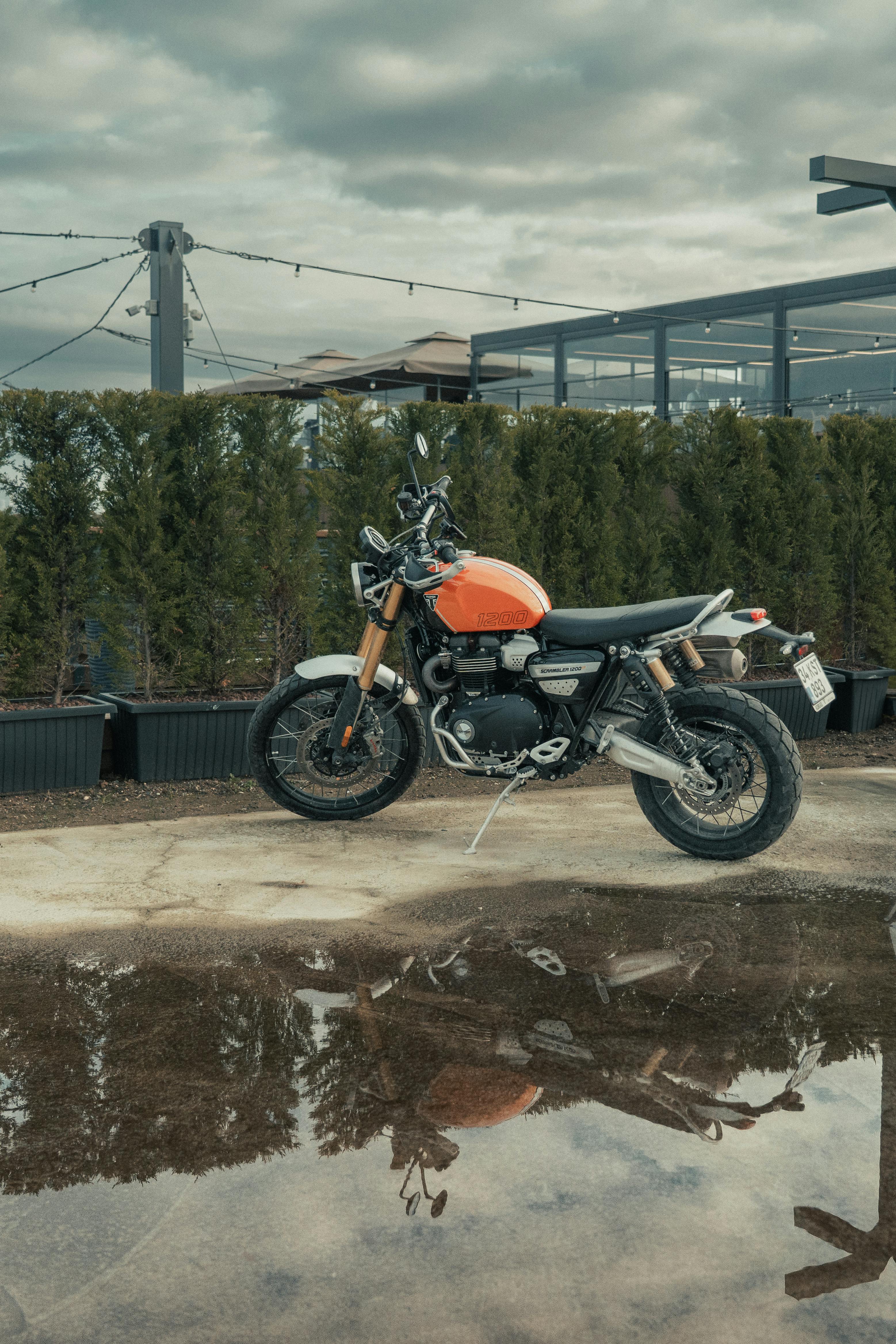 Stylish Motorcycle Reflected in Puddle Outdoors · Free Stock Photo