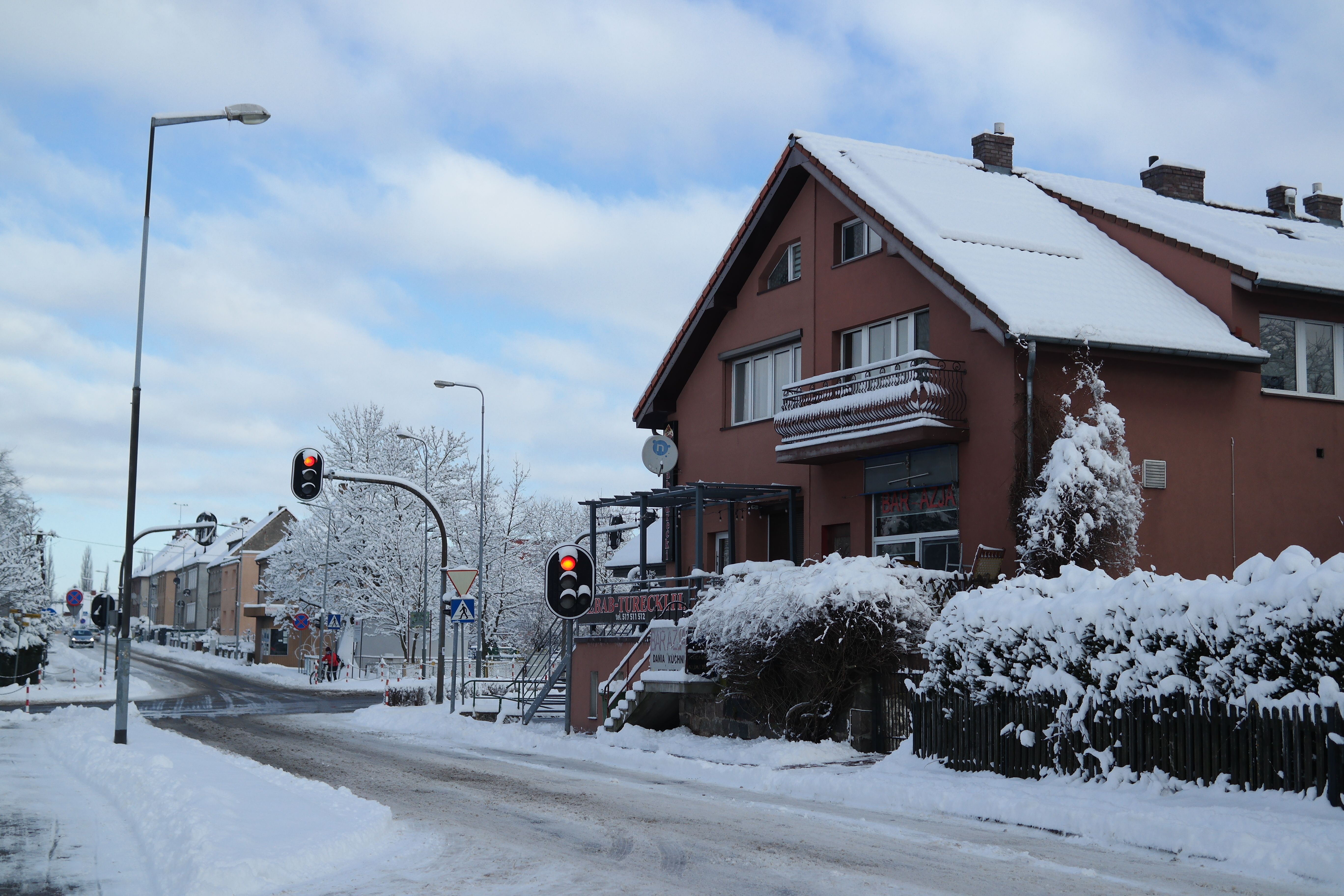 Snow-covered suburban street with traffic lights · Free Stock Photo