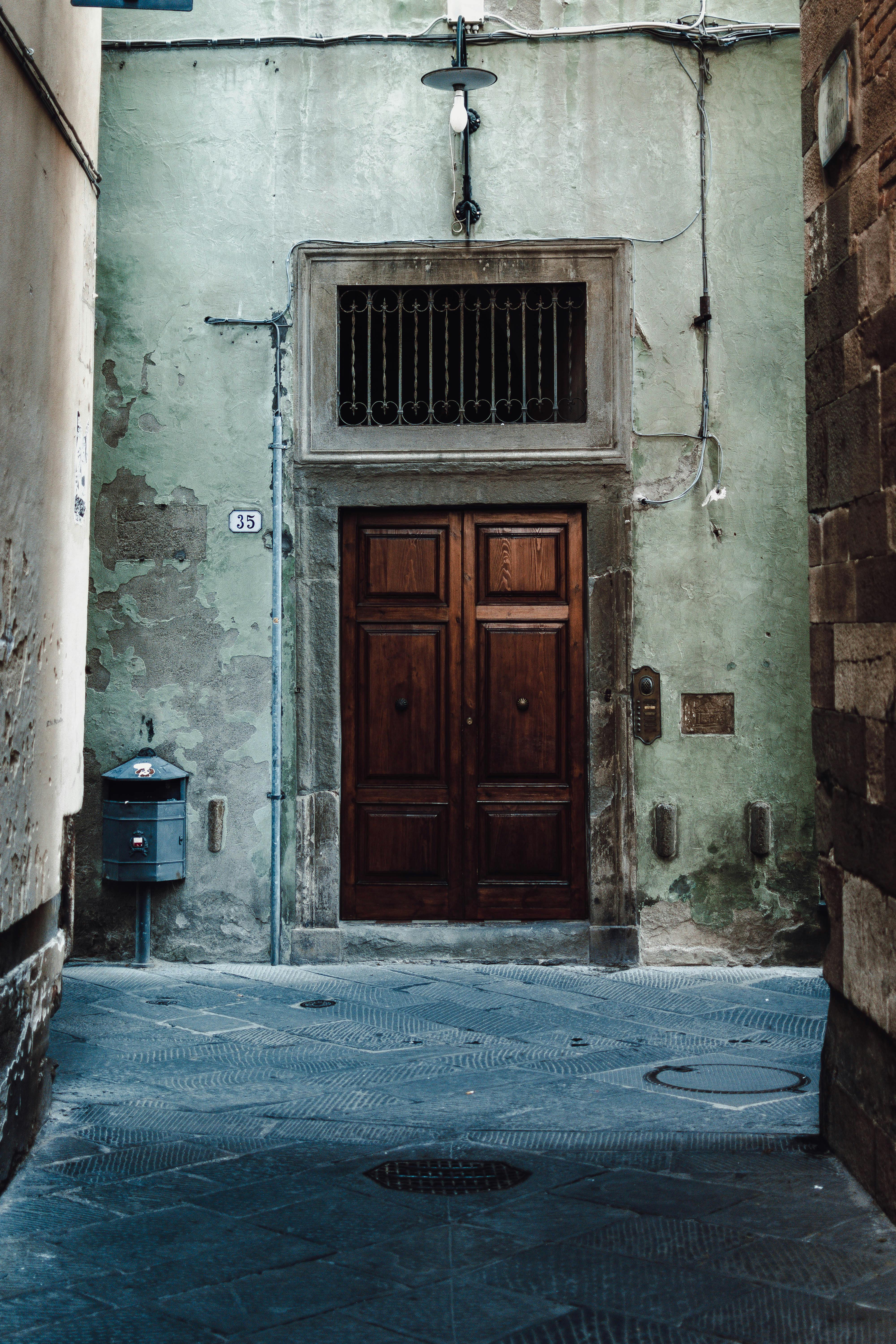 Historic Wooden Door in Narrow European Alley · Free Stock Photo
