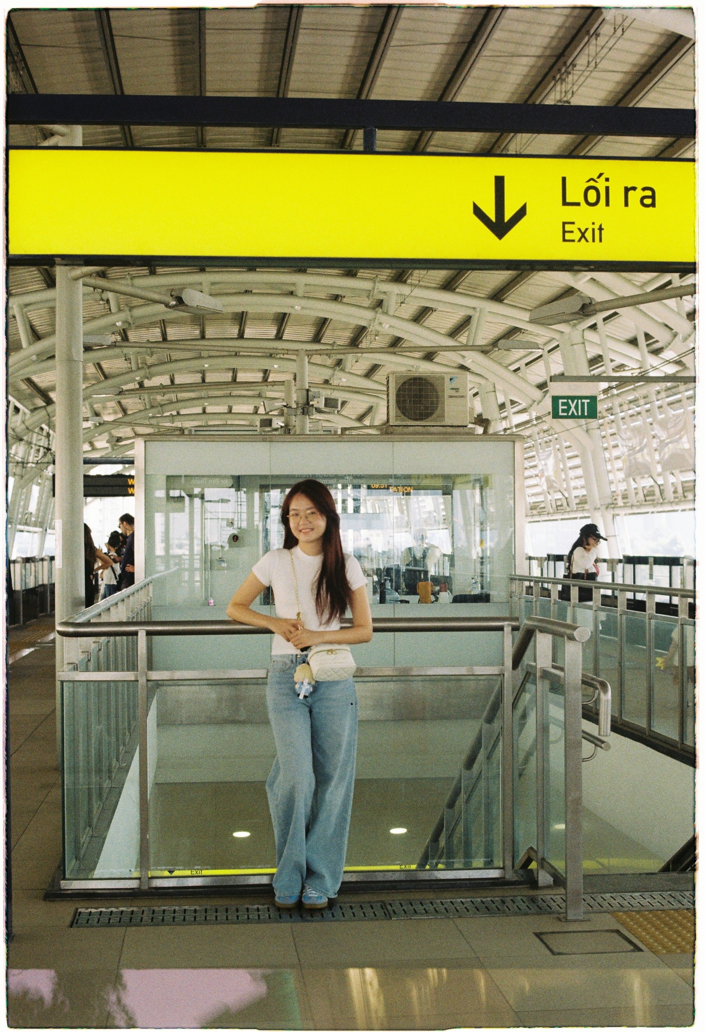 Woman standing in modern building with exit sign · Free Stock Photo