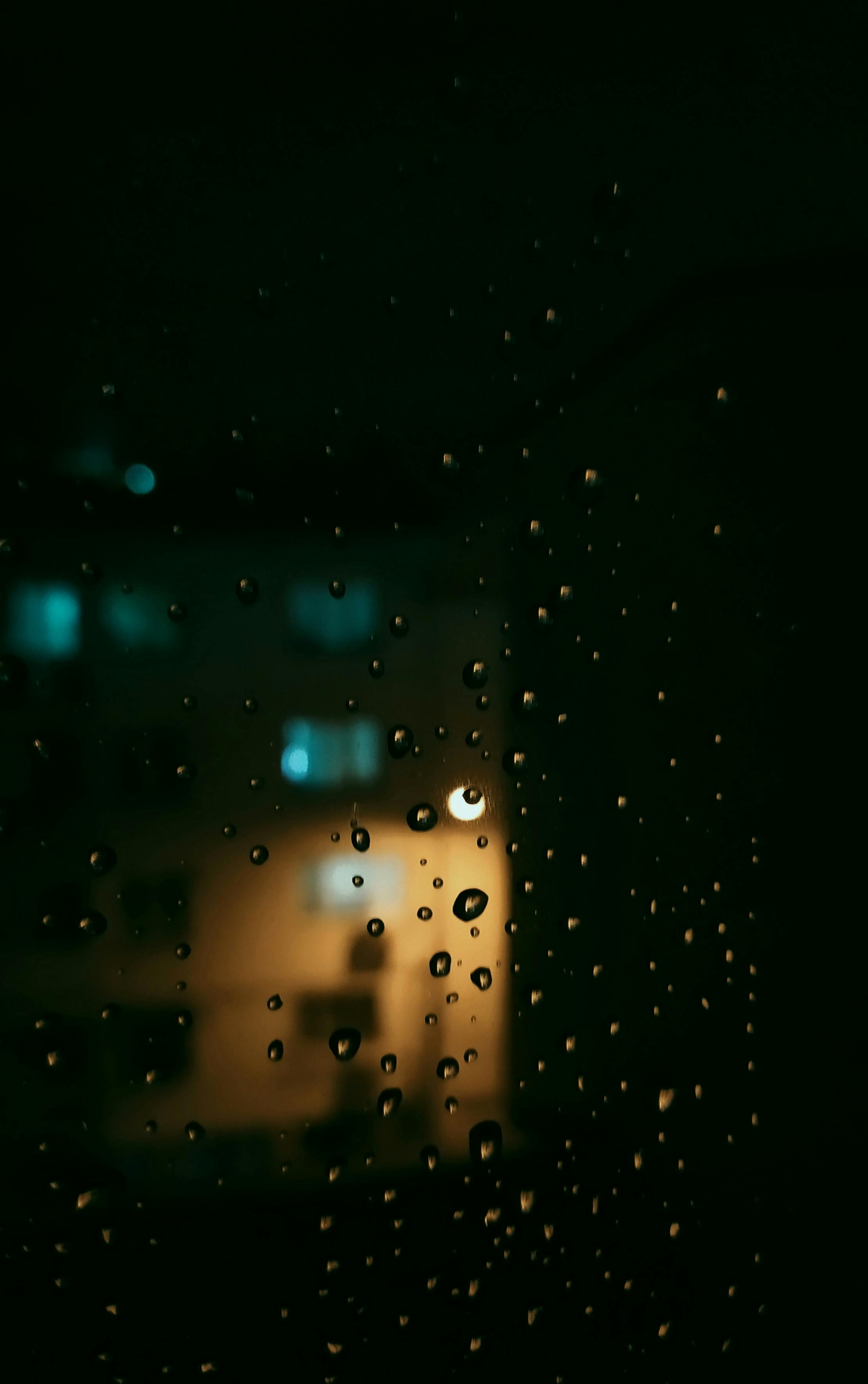 Moody Raindrops on Window with Night View · Free Stock Photo