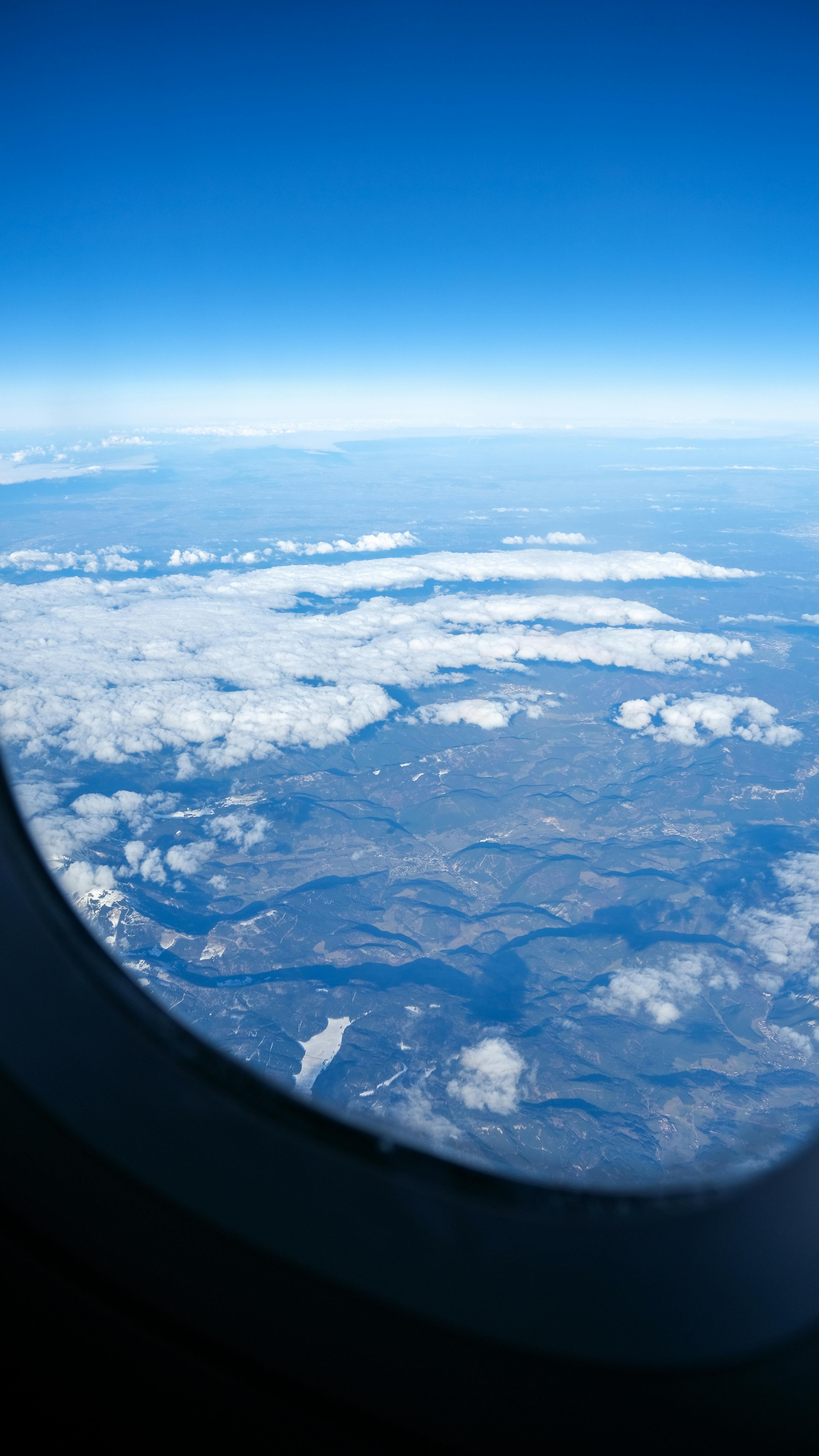 Mountains and Clouds Outside of an Airplane Window · Free Stock Photo