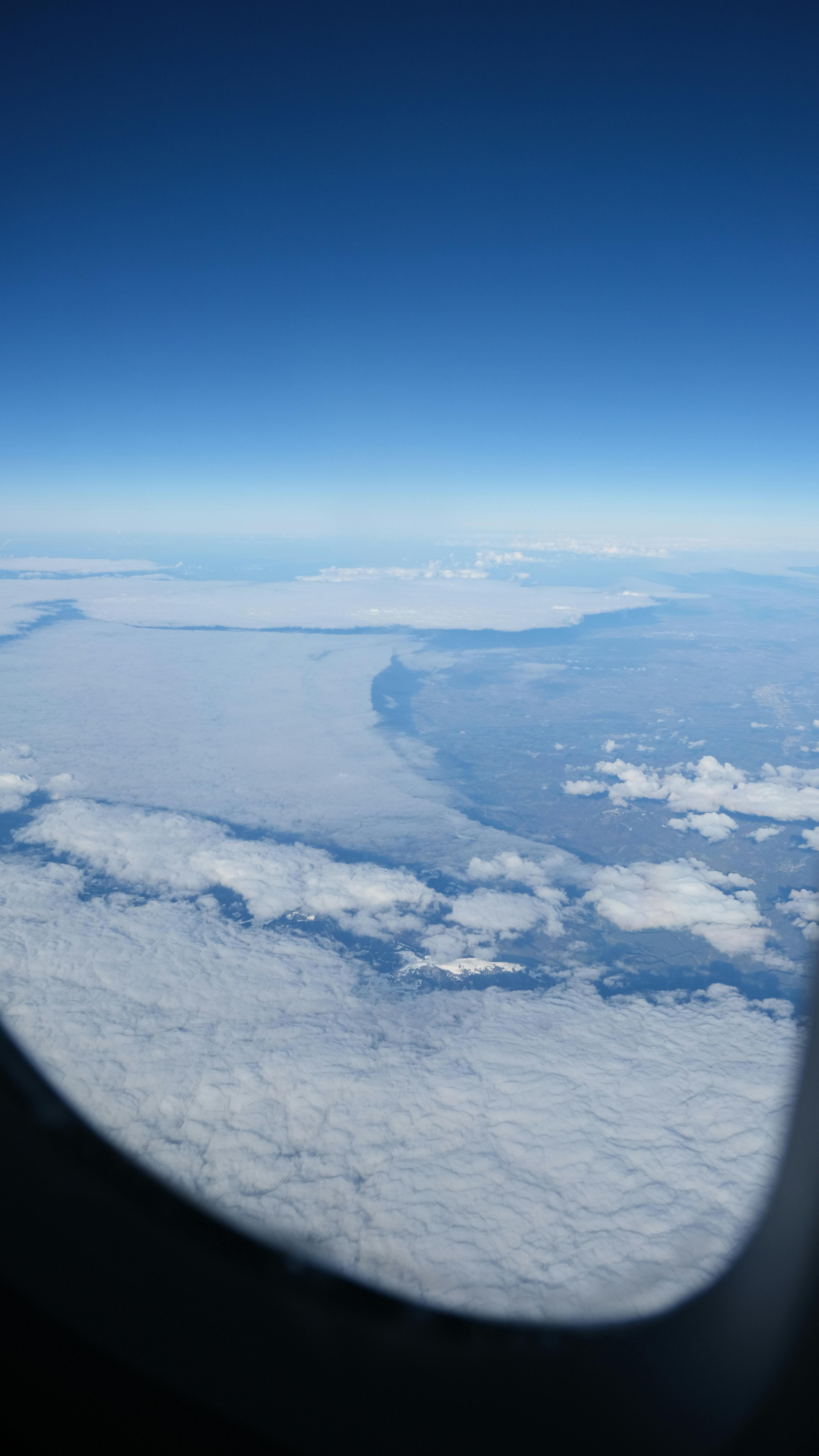 Aerial View of Clouds and Earth from Plane Window · Free Stock Photo