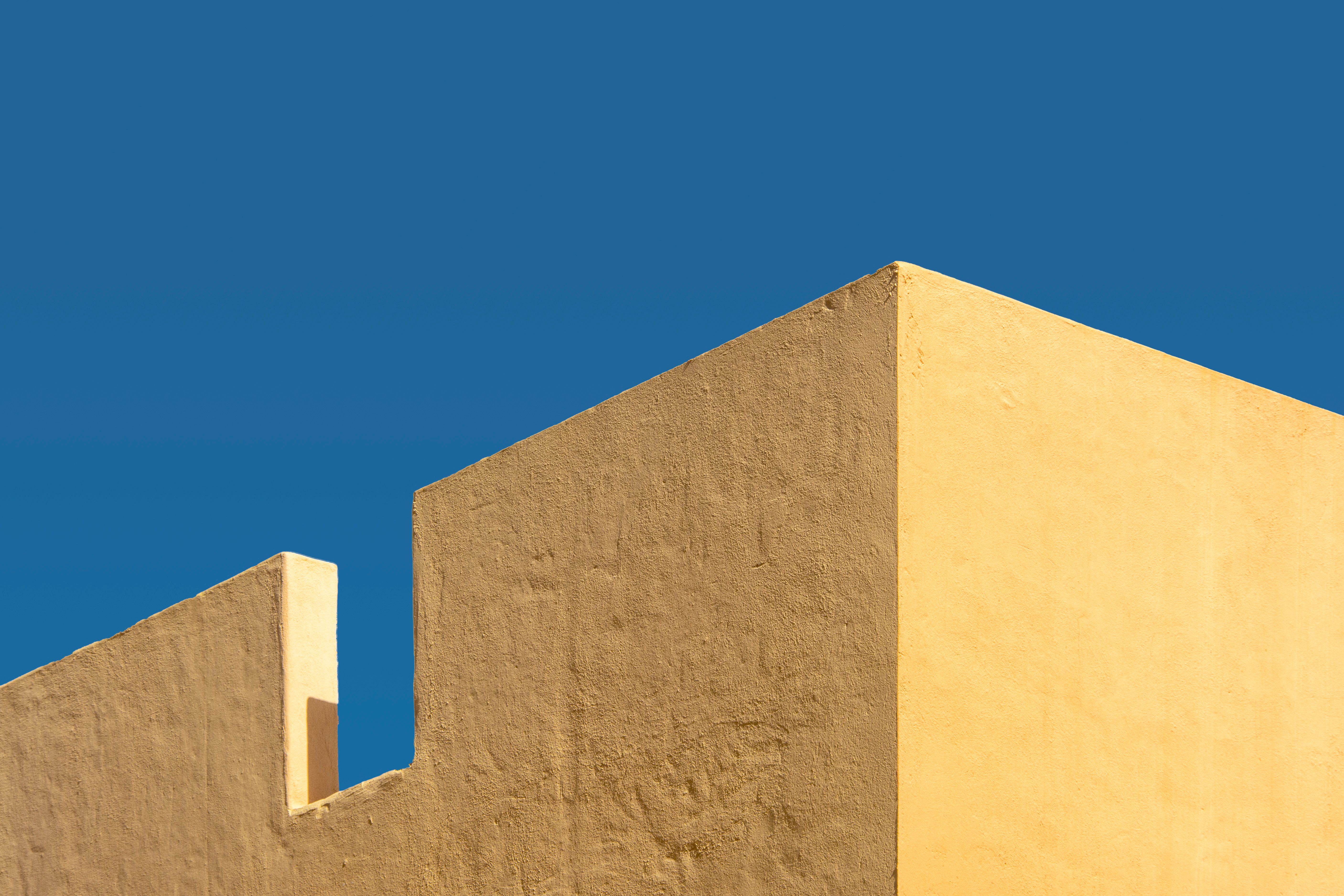 Minimalist Yellow Building Against Clear Blue Sky · Free Stock Photo