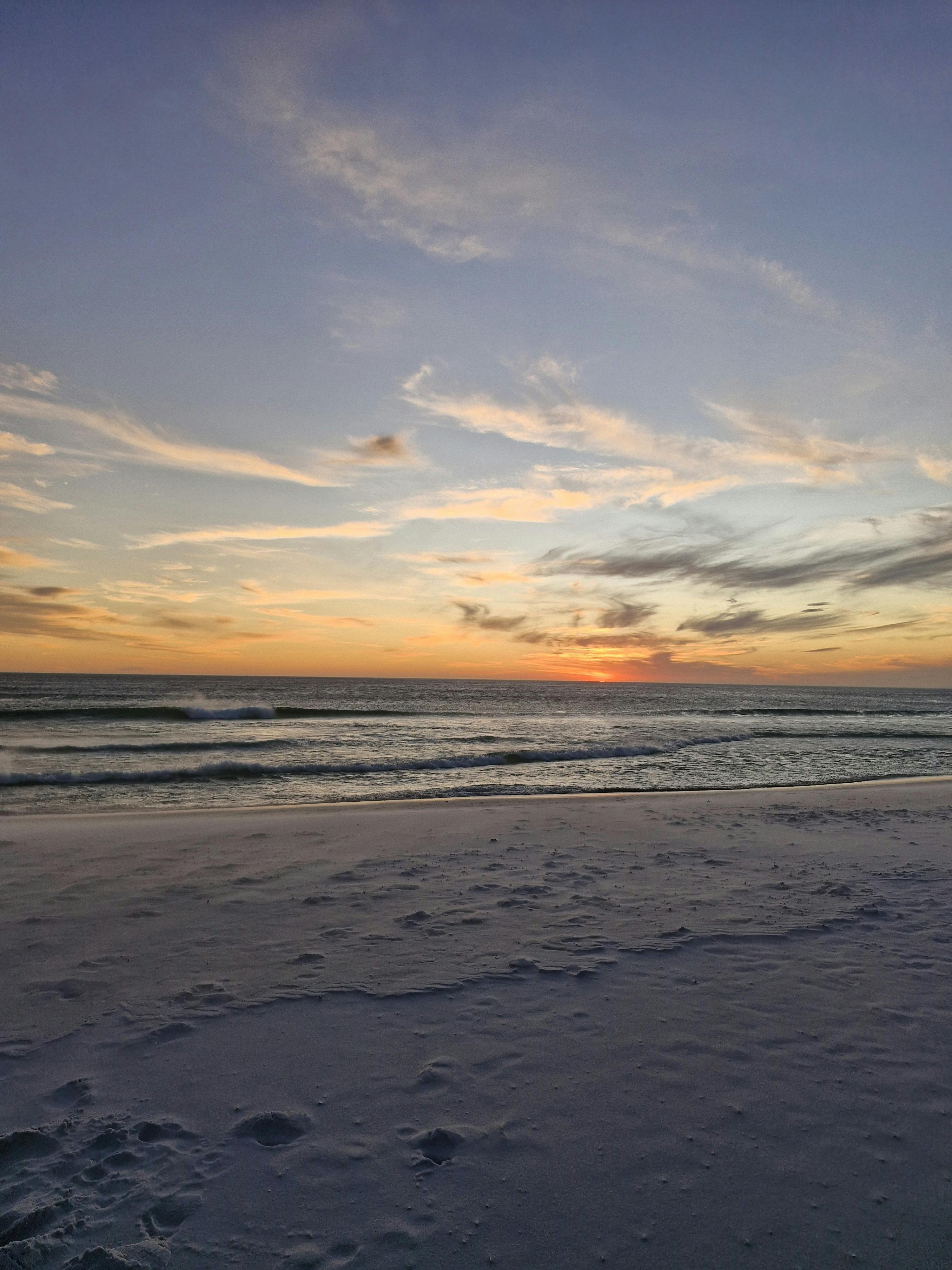 Praia Serena Ao Pôr Do Sol Com Céu Dramático · Foto profissional gratuita